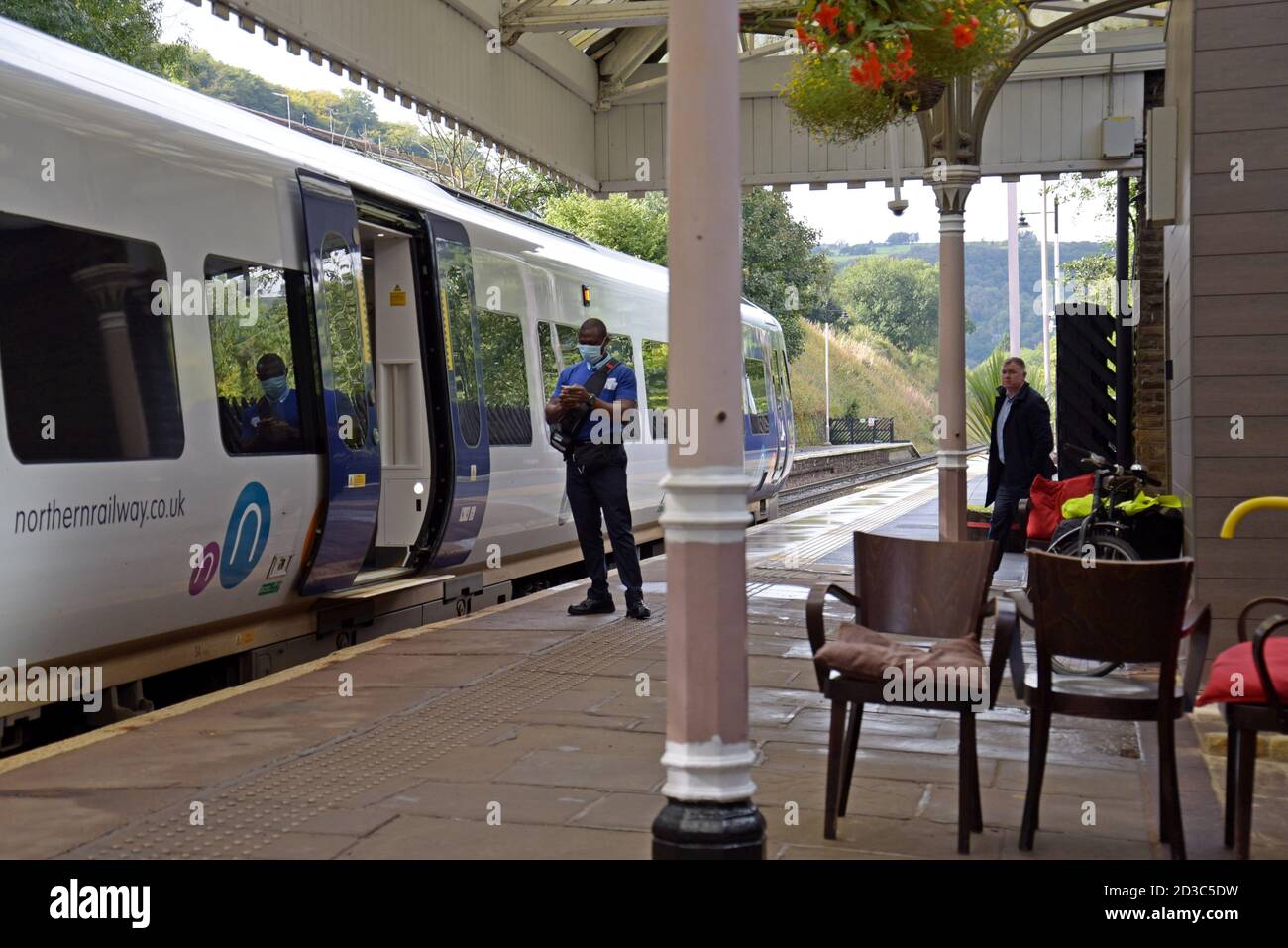 A Northern Railway train guard wearing a face mask on the platform at ...