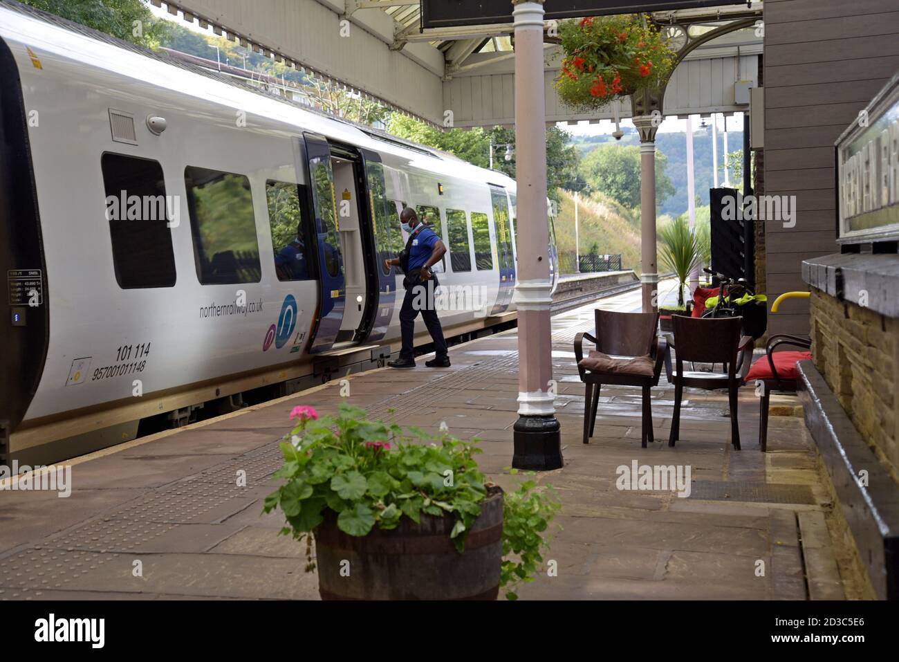 A Northern Railway train guard wearing a face mask on the platform at ...