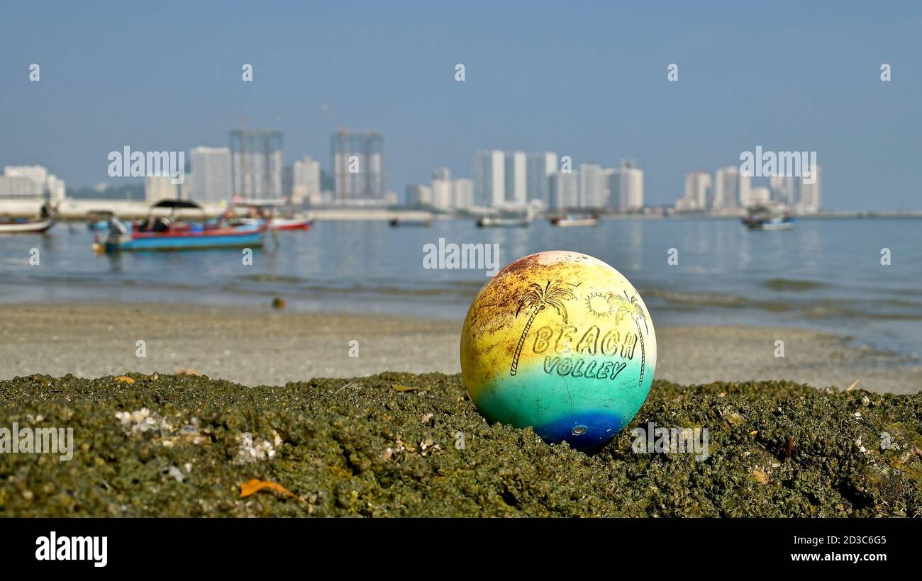 A perspective shot of a beach volleyball ball in the foreground against ...