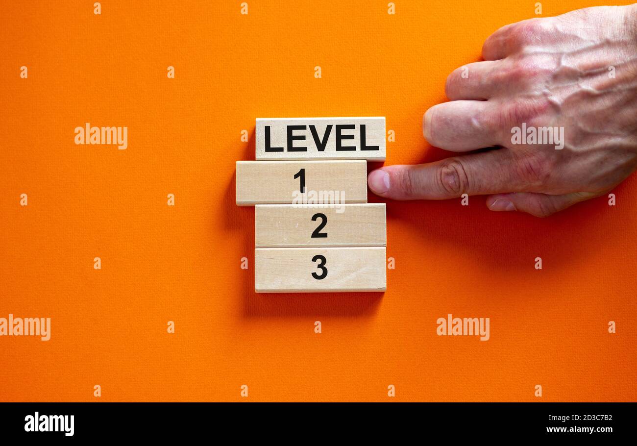 Wooden blocks form the words 'level, 1, 2, 3,' on orange background ...