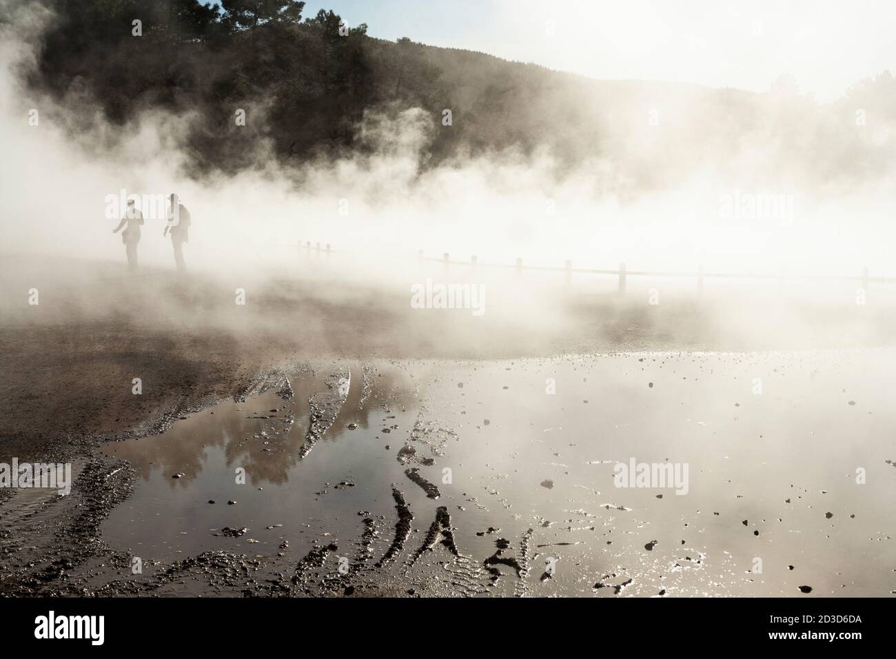 Two people in the mist rising from thermal pools Stock Photo - Alamy
