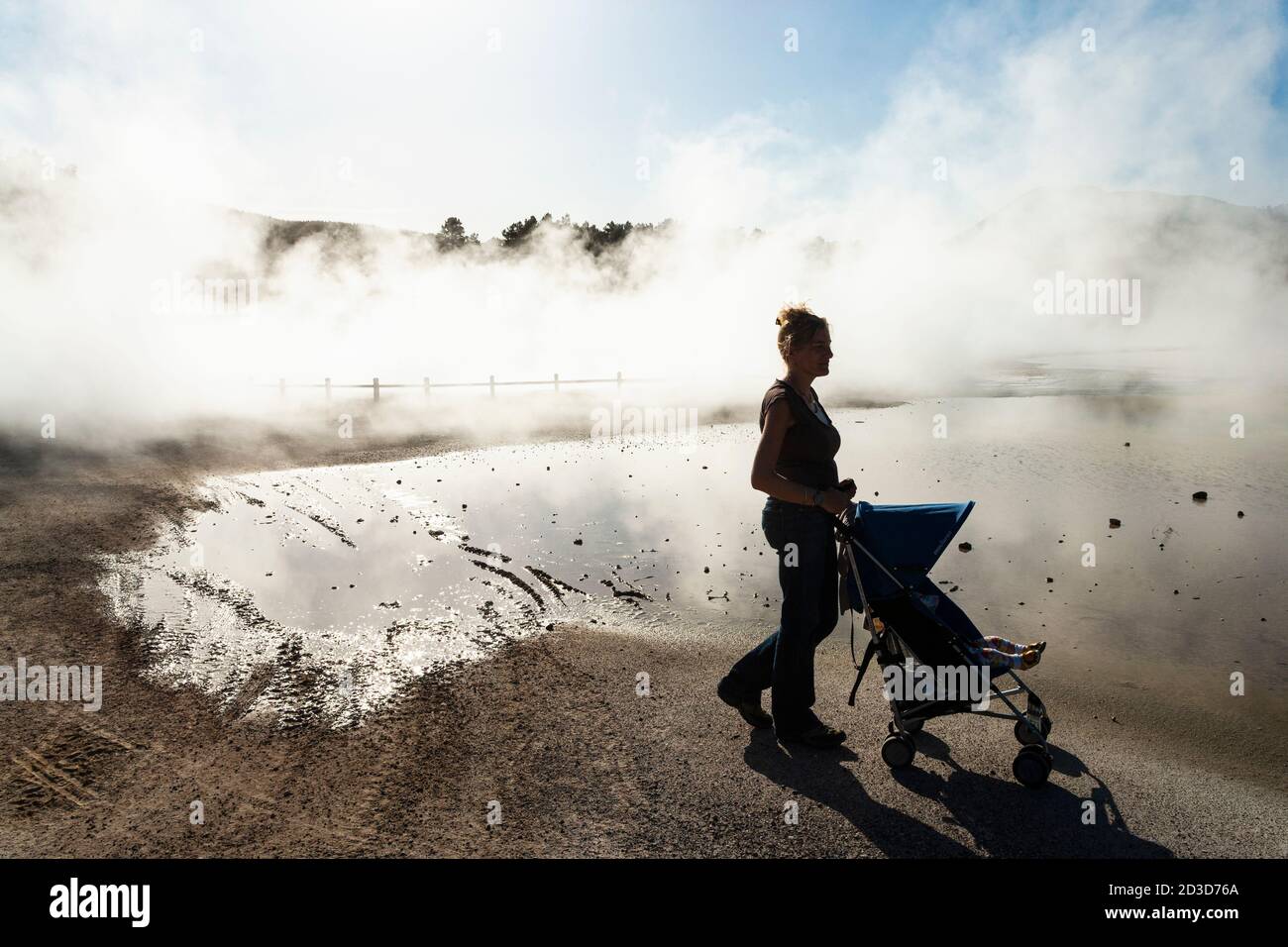 A woman and a child in a buggy in rising steam from thermal pools Stock ...