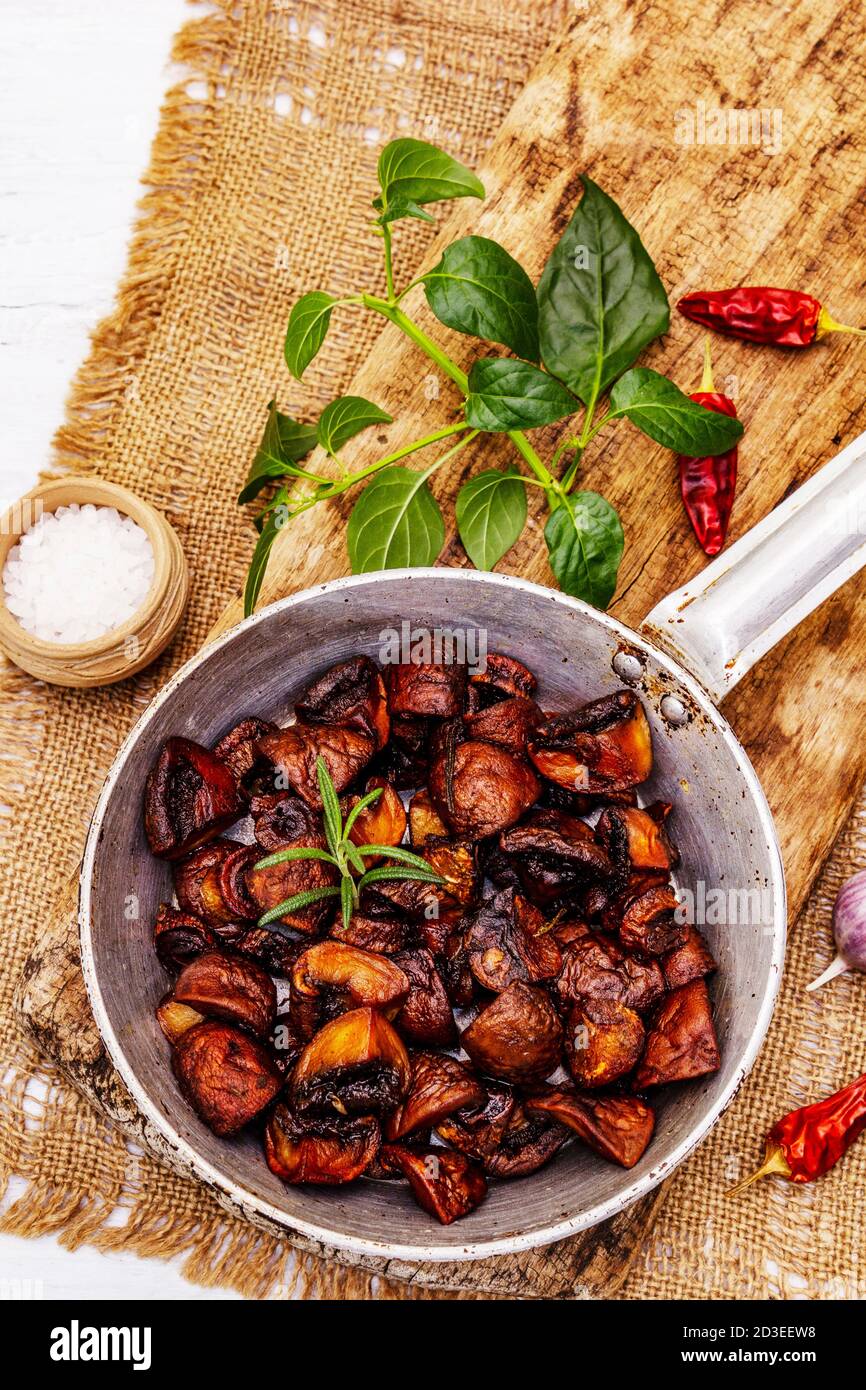 Ready to eat hot fried brown champignons in vintage pan. Royal ...