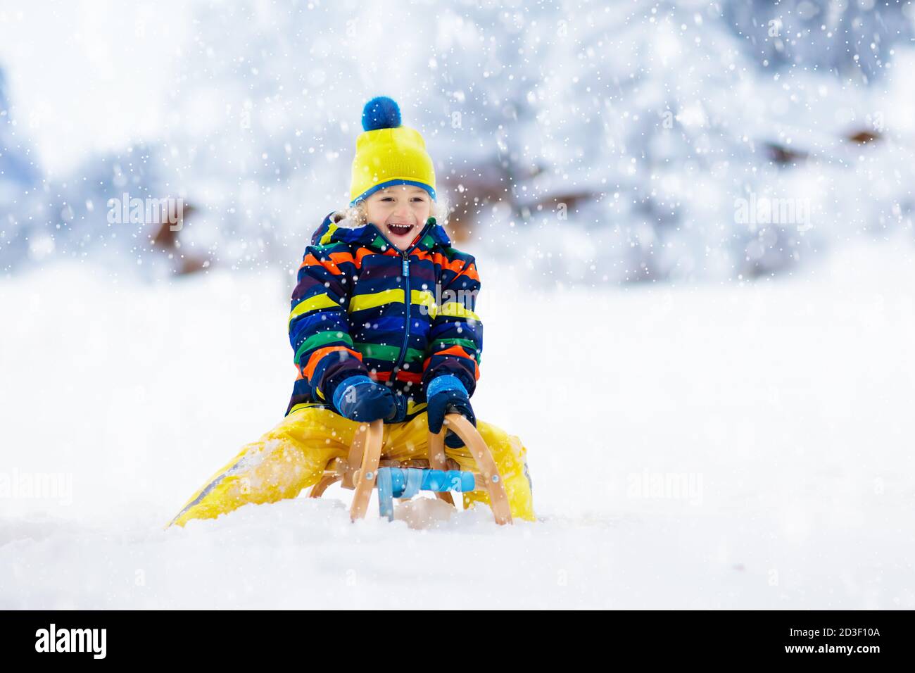 Little boy enjoying a sleigh ride. Child sledding. Toddler kid riding a ...