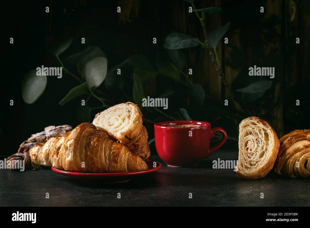 Fresh baked whole and sliced croissant with red cup of coffee espresso ...