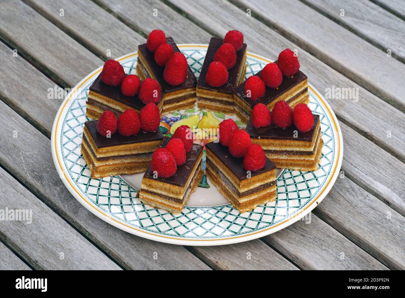 Slices of opera chocolate cake with fresh raspberries Stock Photo - Alamy