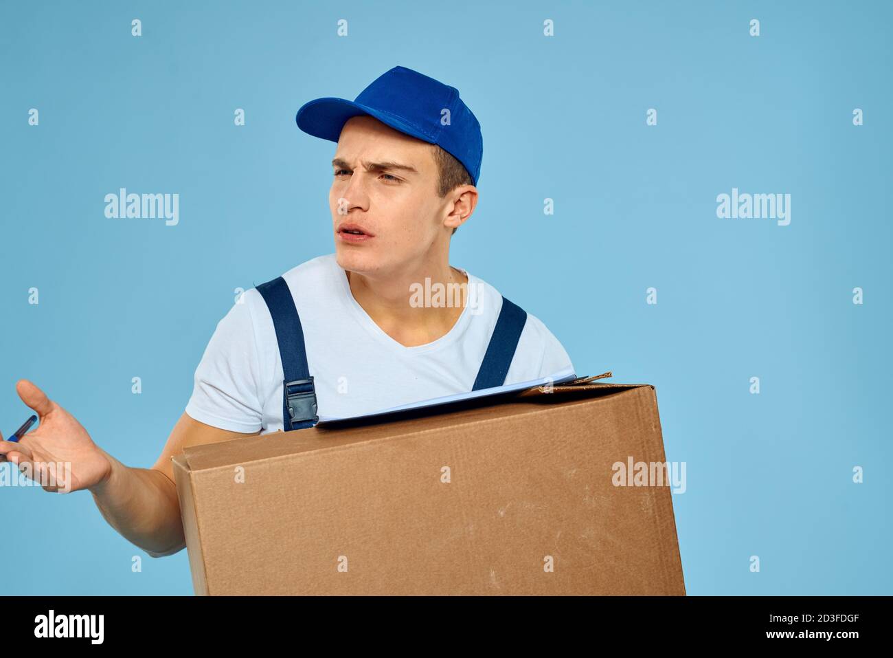 Man worker with cardboard box delivery loader lifestyle blue background ...