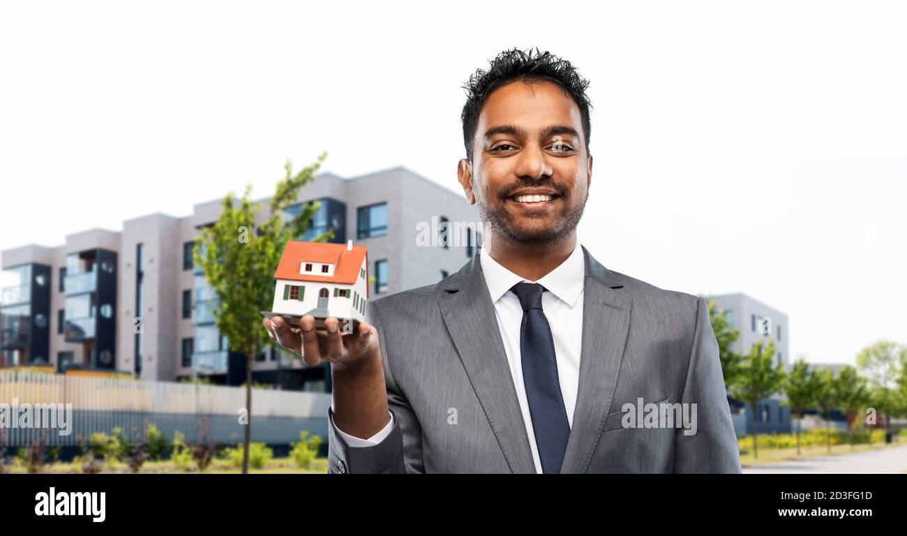 indian man realtor with house model on city street Stock Photo - Alamy