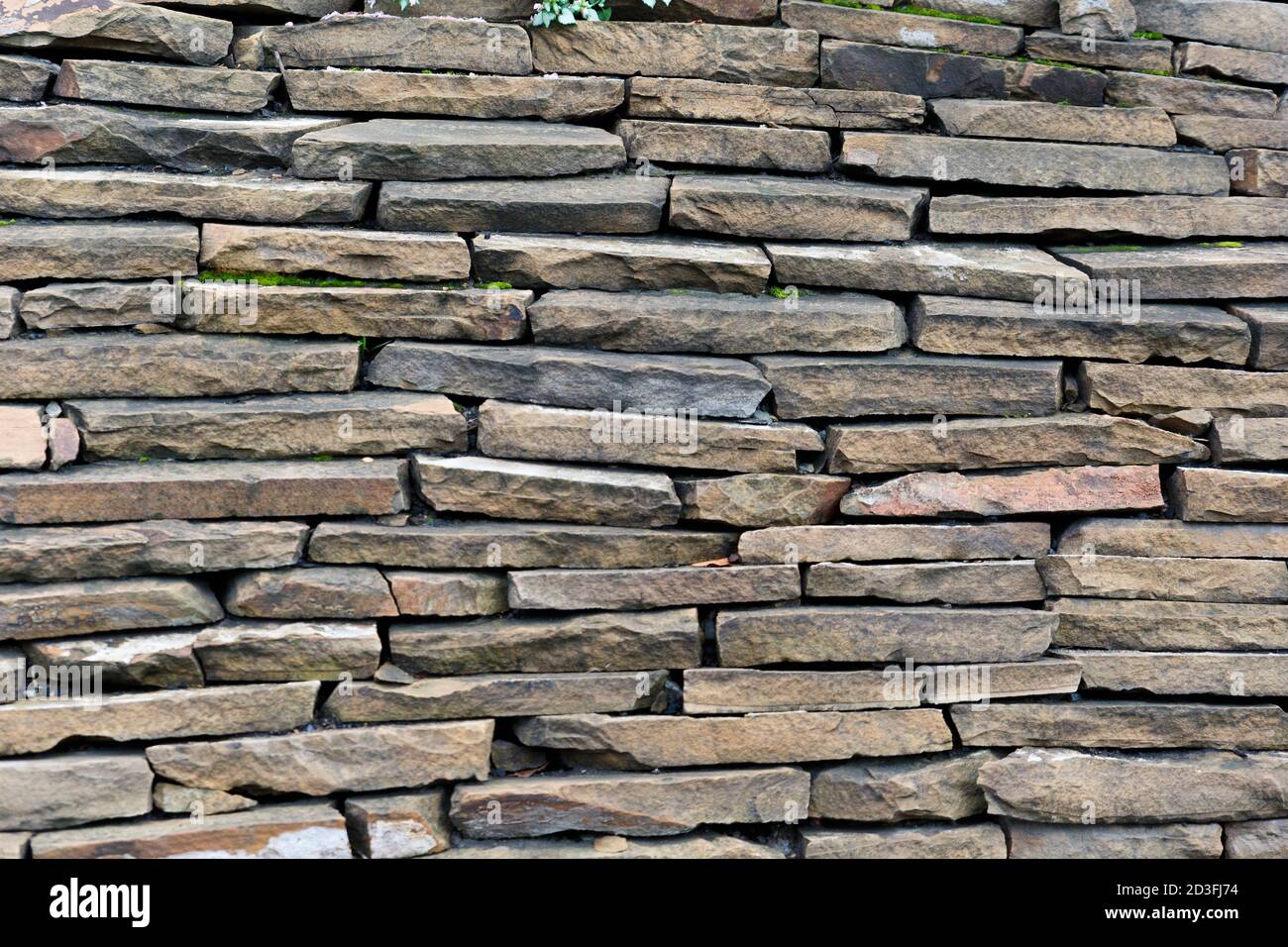 Flat stone sides laid in several rows horizontally. Old stone wall ...