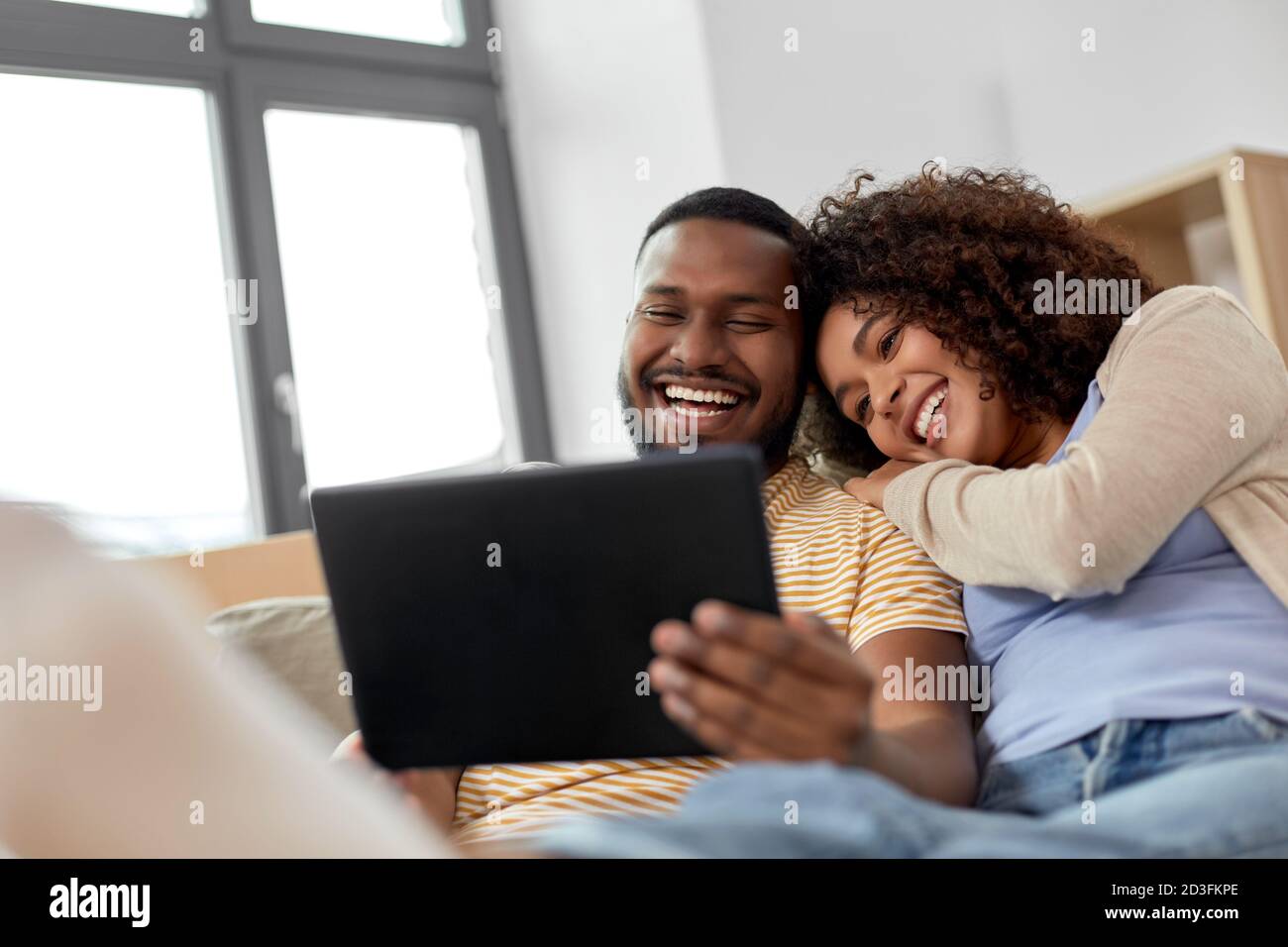 happy couple with tablet pc computer at new home Stock Photo - Alamy
