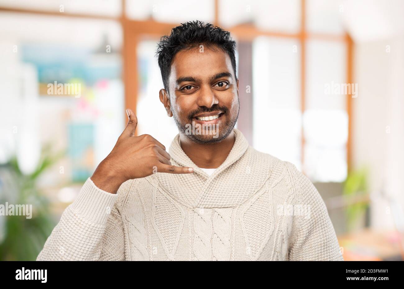indian man in sweater making phone call gesture Stock Photo - Alamy
