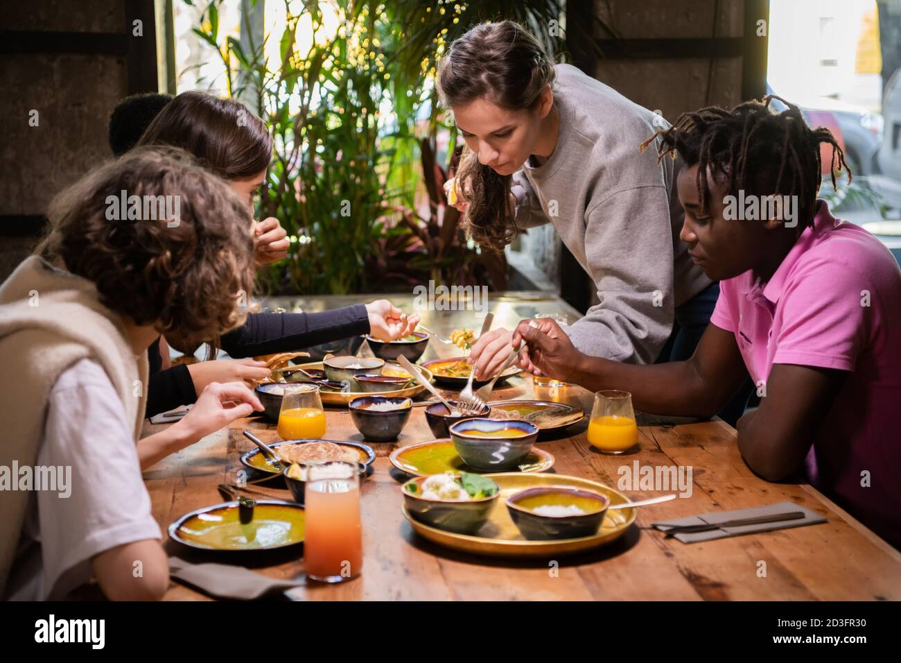 A multicultural group of students sharing food in a cafe Stock Photo ...