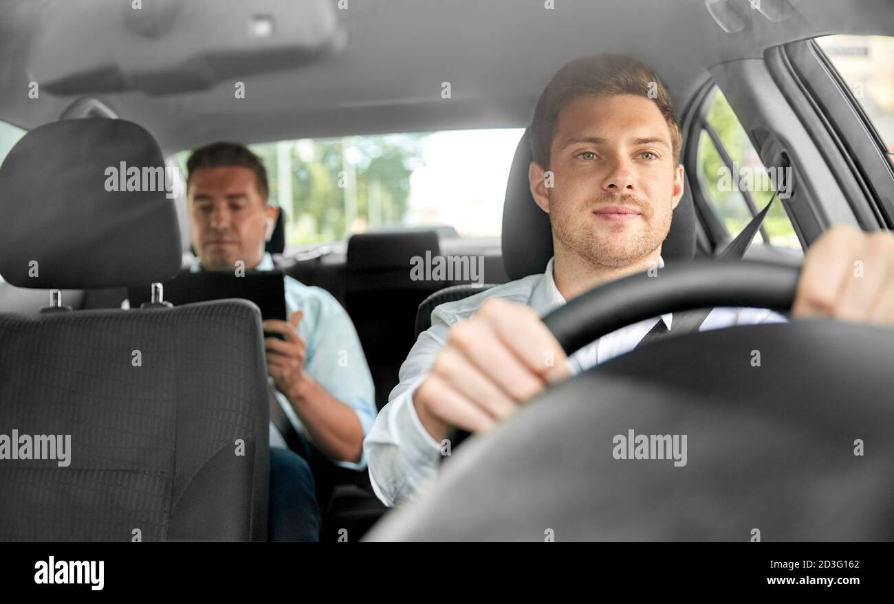 male taxi driver driving car with passenger Stock Photo - Alamy