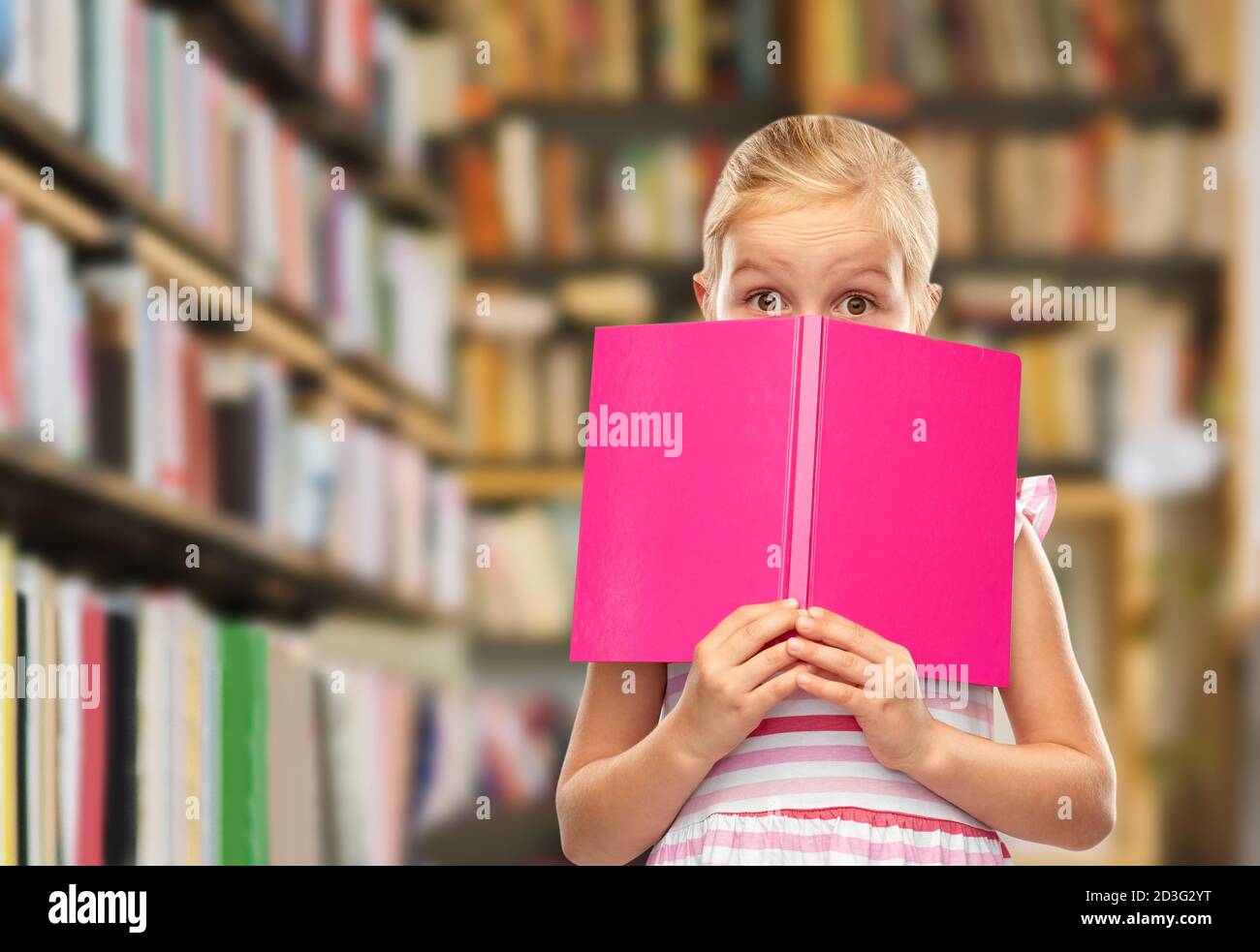 little girl hiding over book at library Stock Photo - Alamy