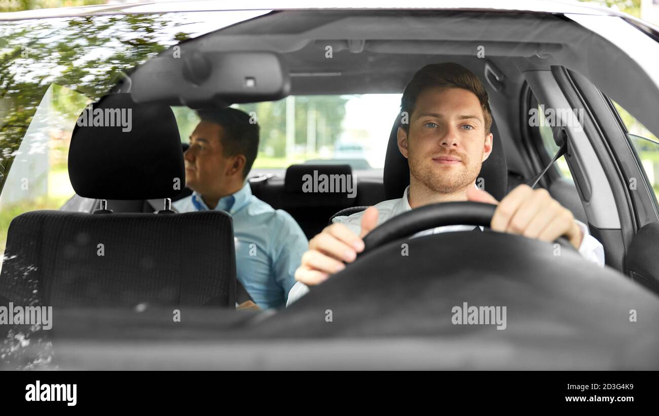 male taxi driver driving car with passenger Stock Photo - Alamy