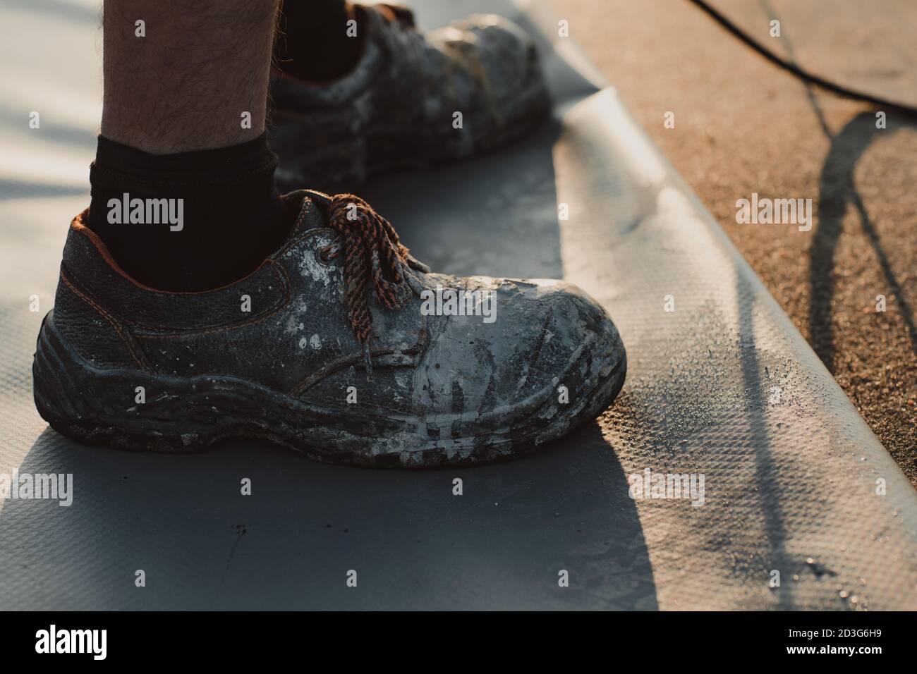 Worker with very worn construction boots Stock Photo - Alamy