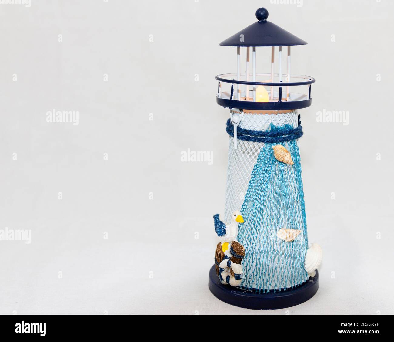 A blue and white small toy lighthouse used for table decoration with a ...