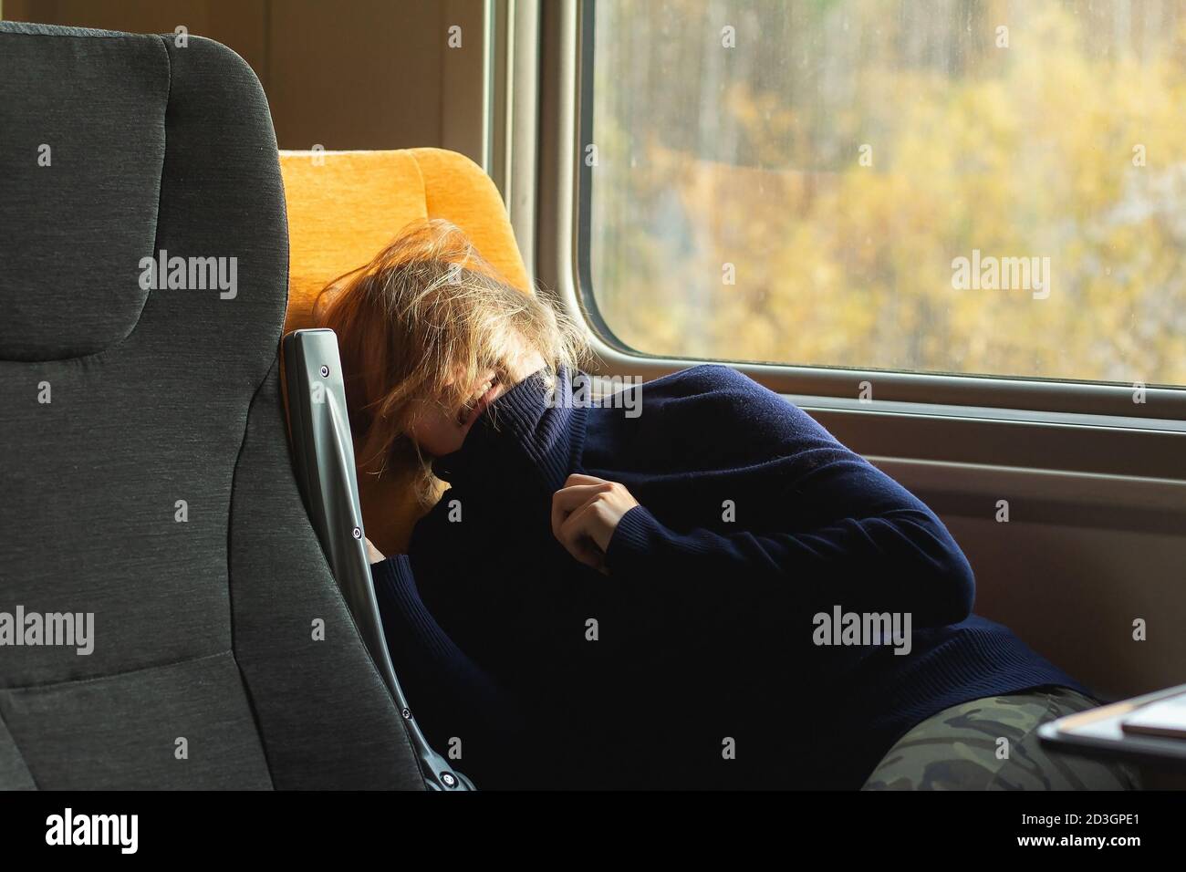 Young woman traveler sleeping inside of suburban train. She covered her ...