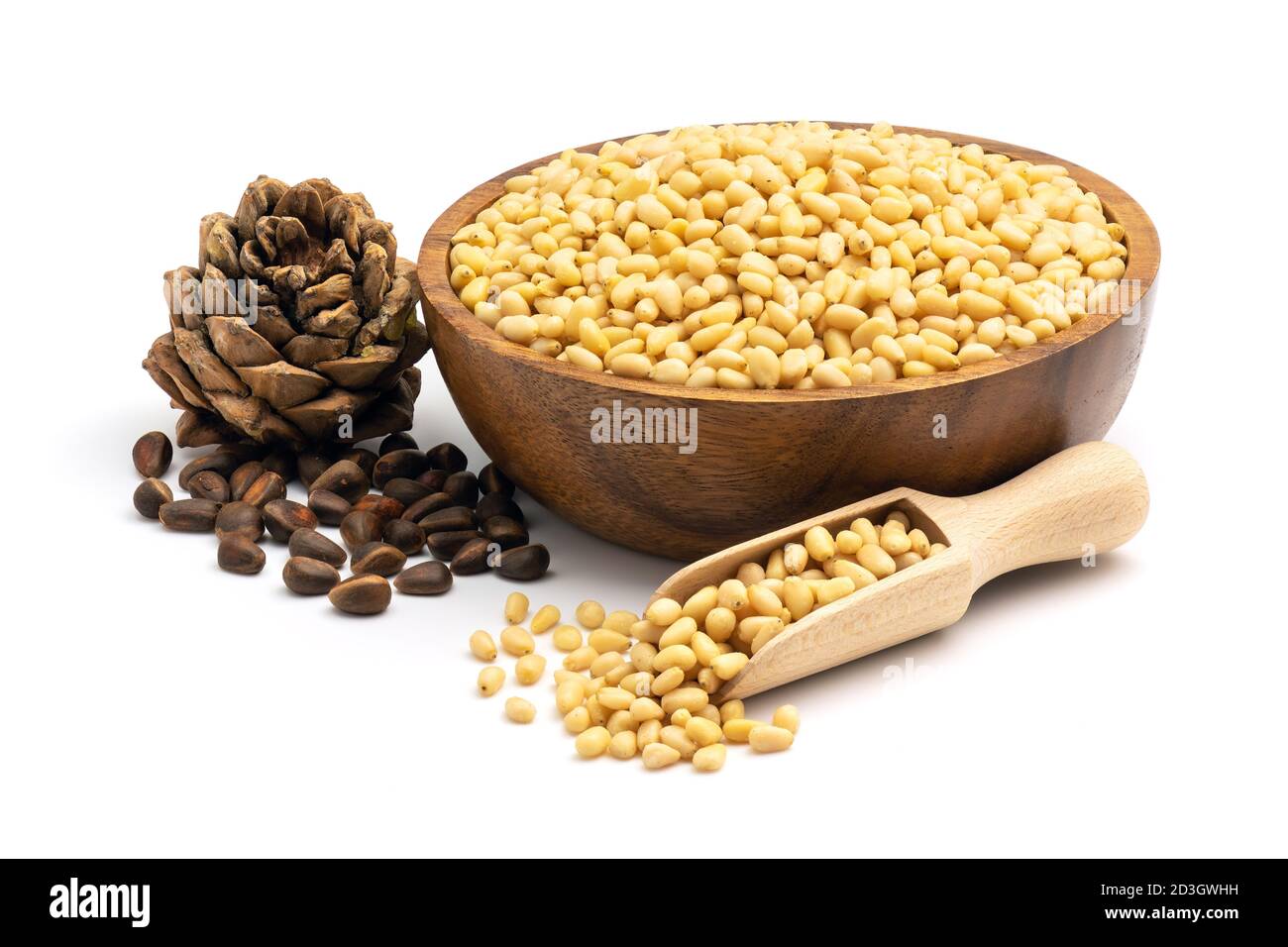 Peeled pine nuts in a wooden bowl and ripe pine cone isolated on a ...