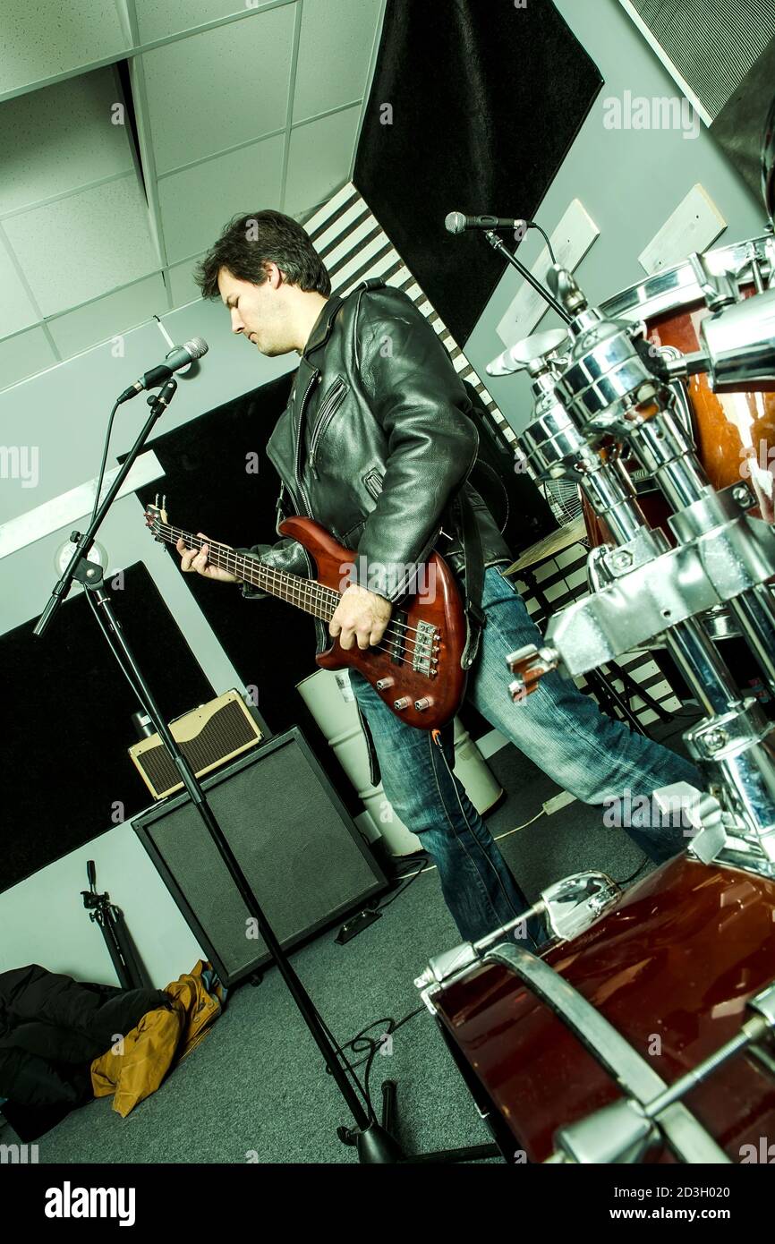 A Rock musician playing passionately bass in the rehearsal Studio Stock ...