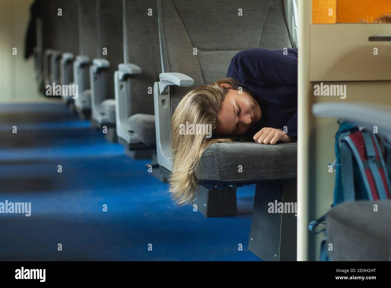 Young woman traveler sleeping inside of suburban train. Empty train ...