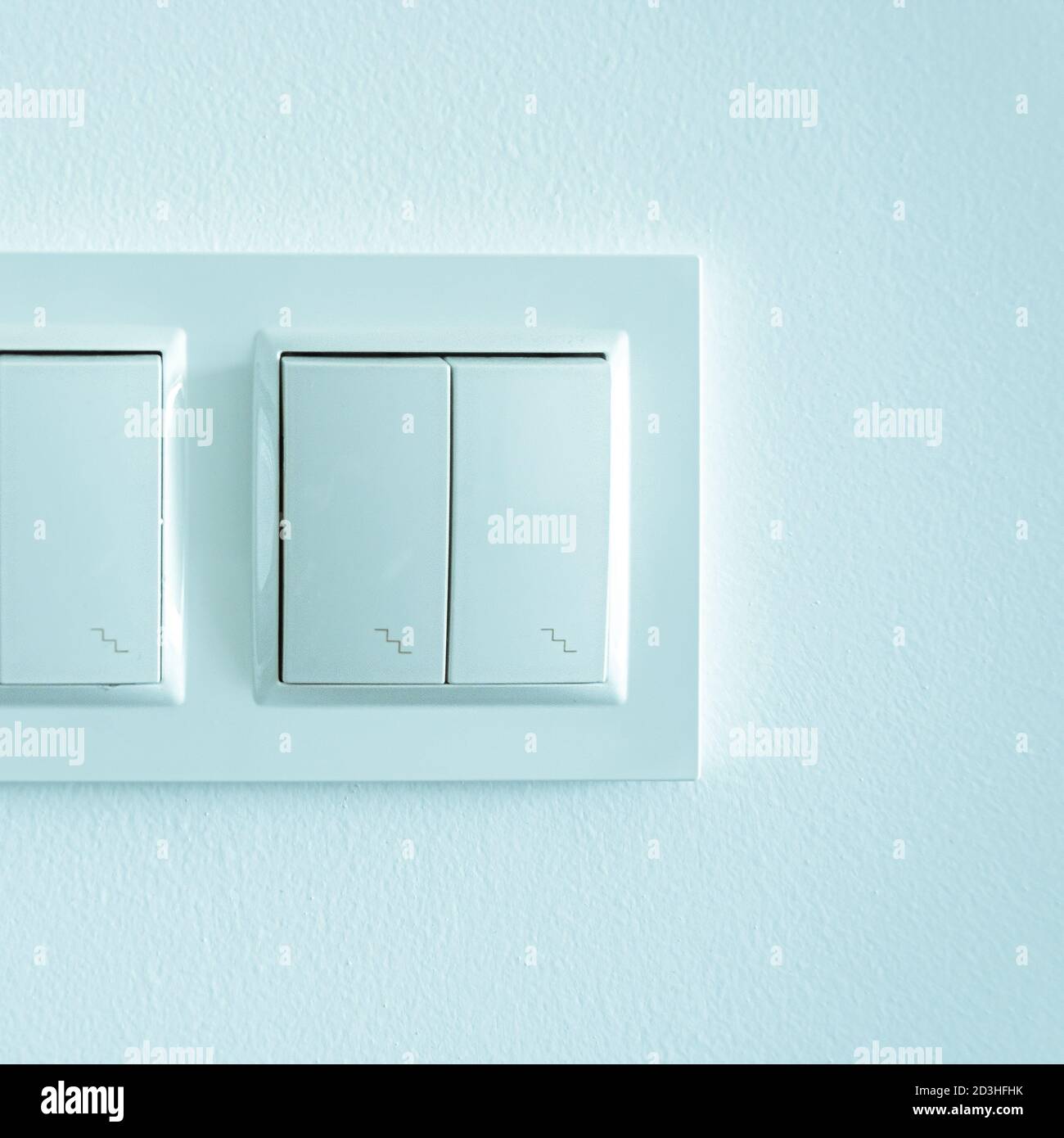 White plastic pass-through electricity switches on a white wall Stock ...