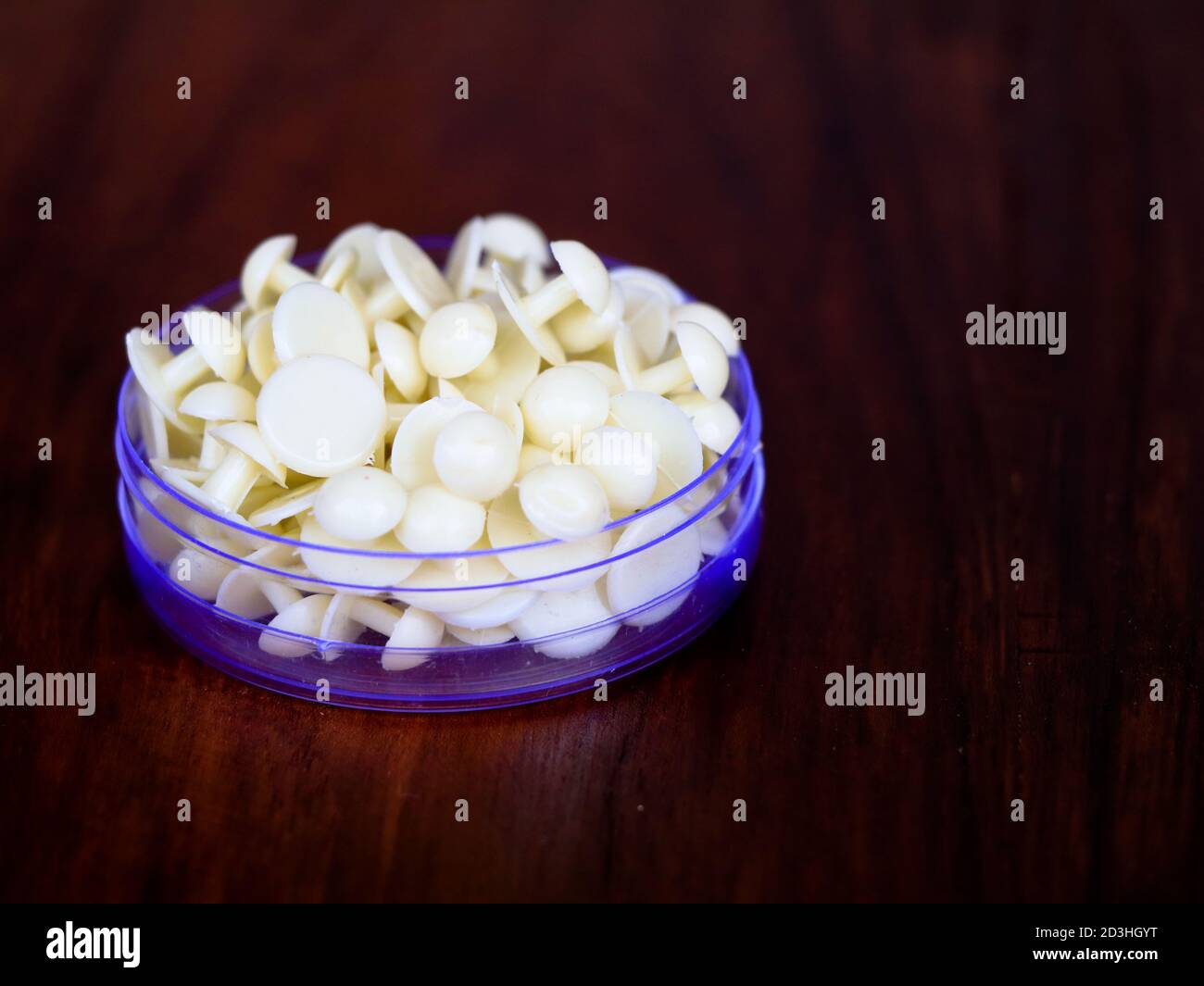 Cream color buttons of cassock against wooden background, selective ...
