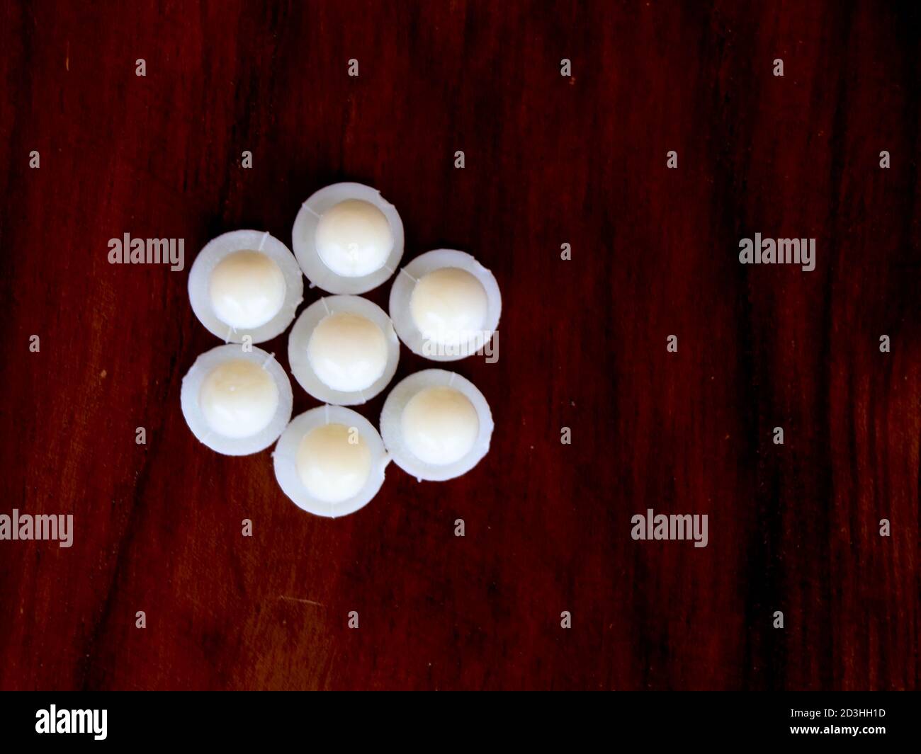 Cream color buttons of cassock against wooden background, selective ...