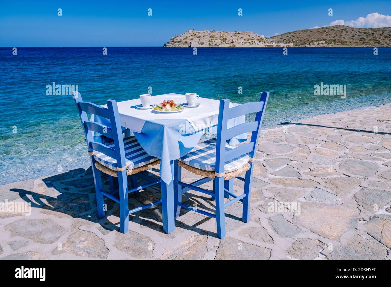 Plaka Lassithi with is traditional blue table and chairs and the beach ...