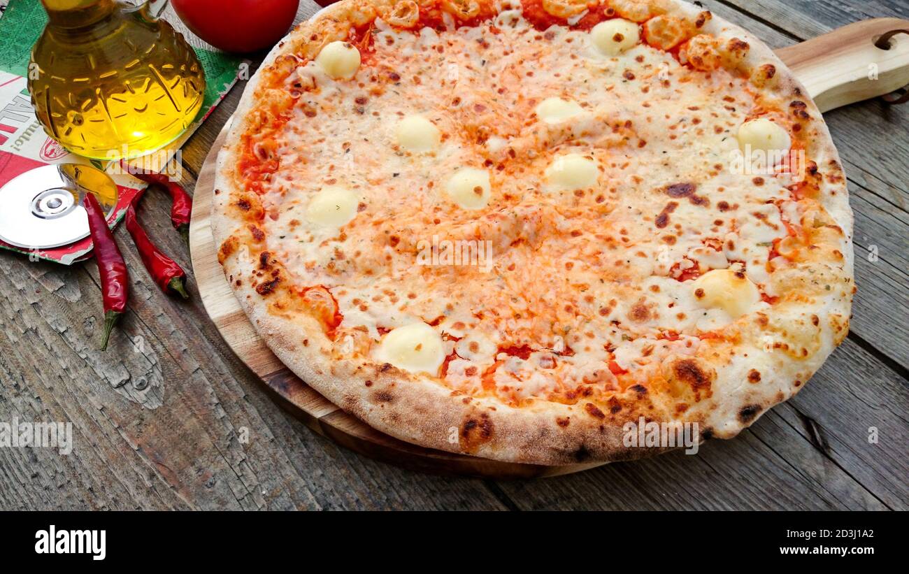 whole margherita pizza on a wooden table Stock Photo - Alamy