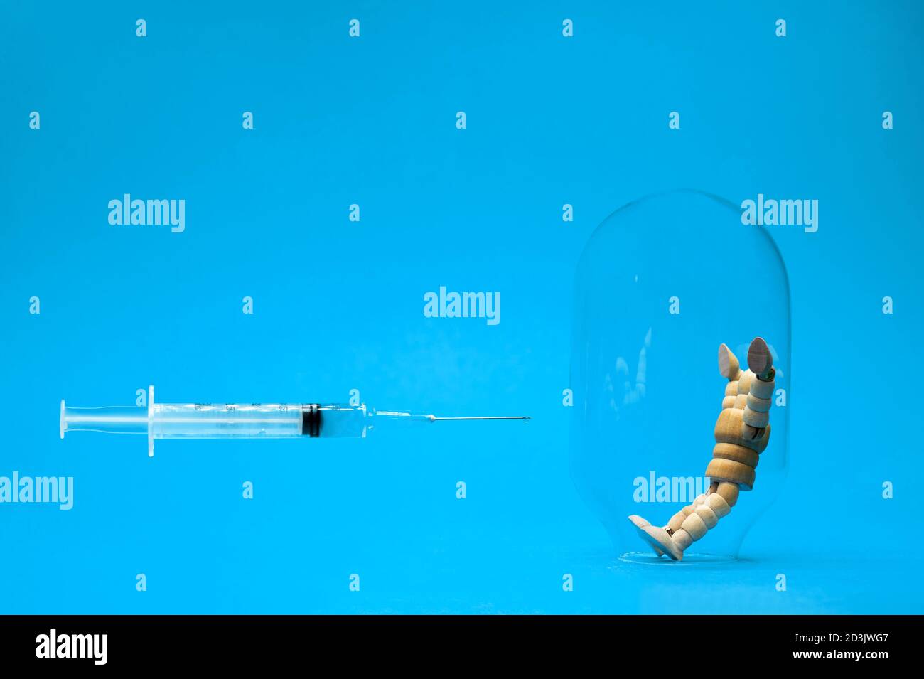 A syringe with a drop of injection at the end of the needle is aimed at ...