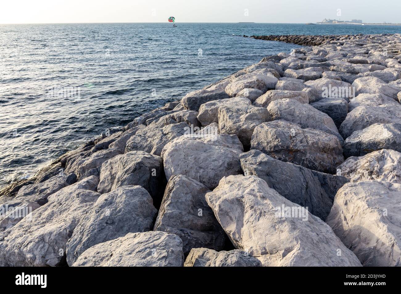 Jetty made of large stones and rocks extending into the sea on ...