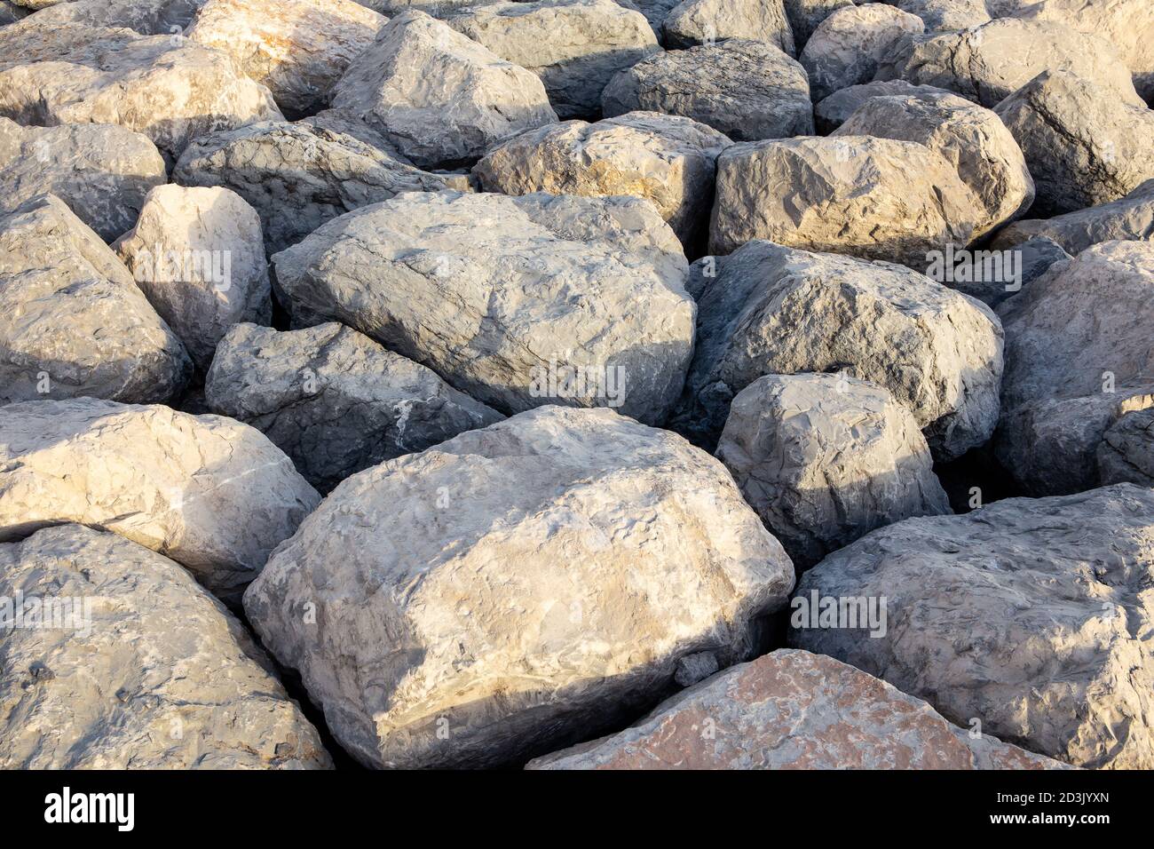 Big rough stones and rocks texture (background), forming a pier in ...