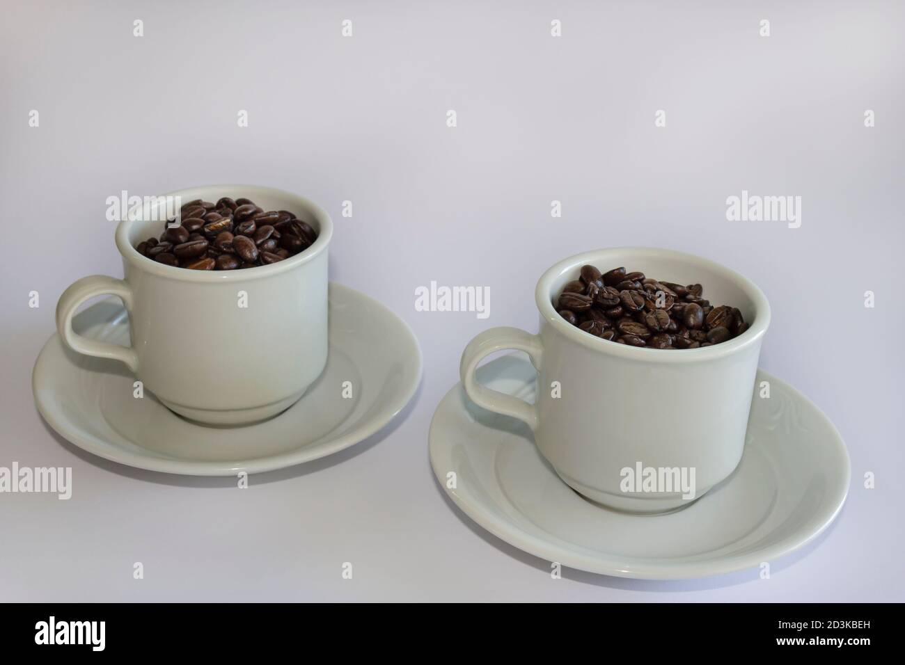 Coffee beans in two coffee cups , on white isolated background Stock ...