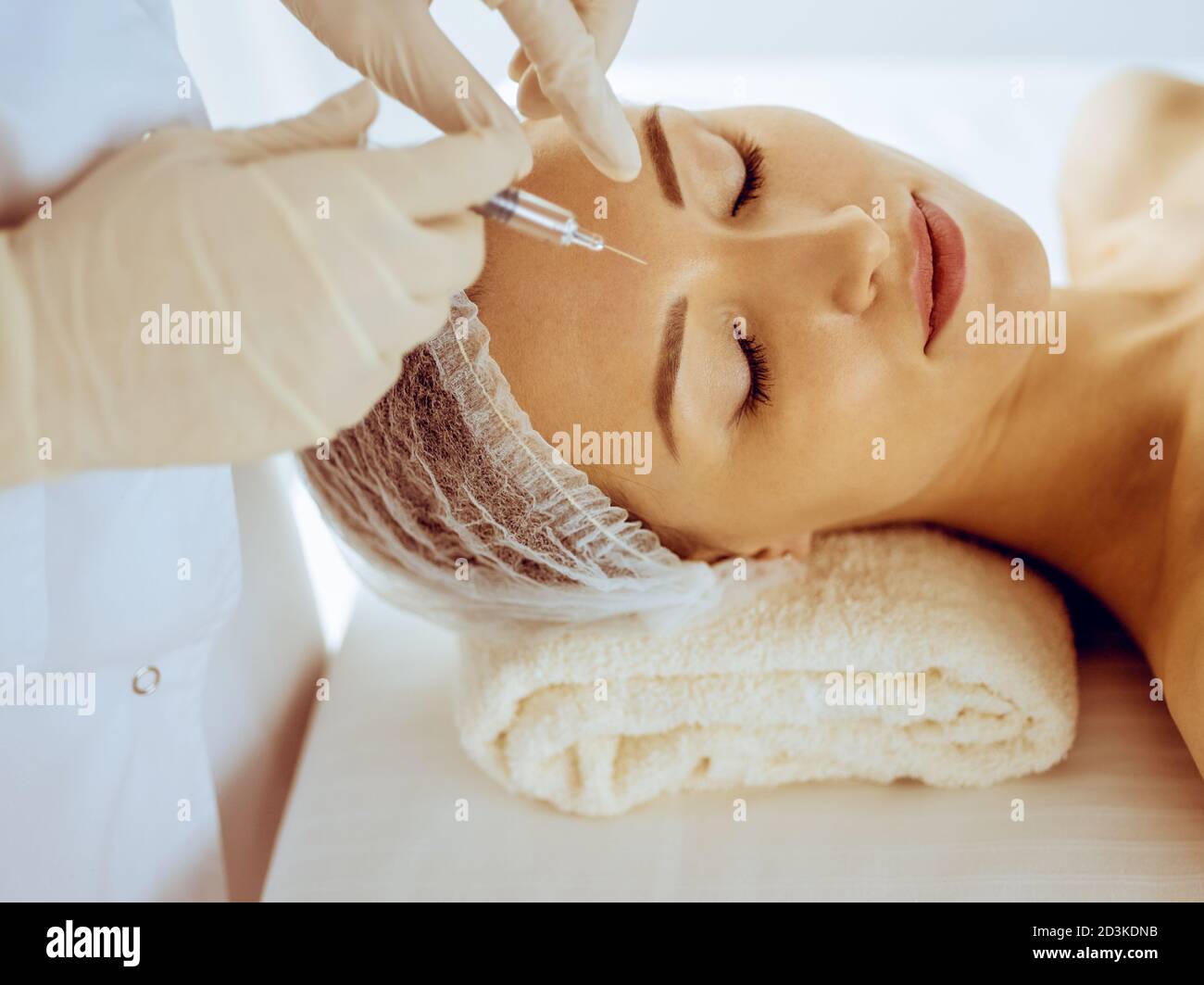 Beautiful woman receiving beauty injections with closed eyes in medical ...