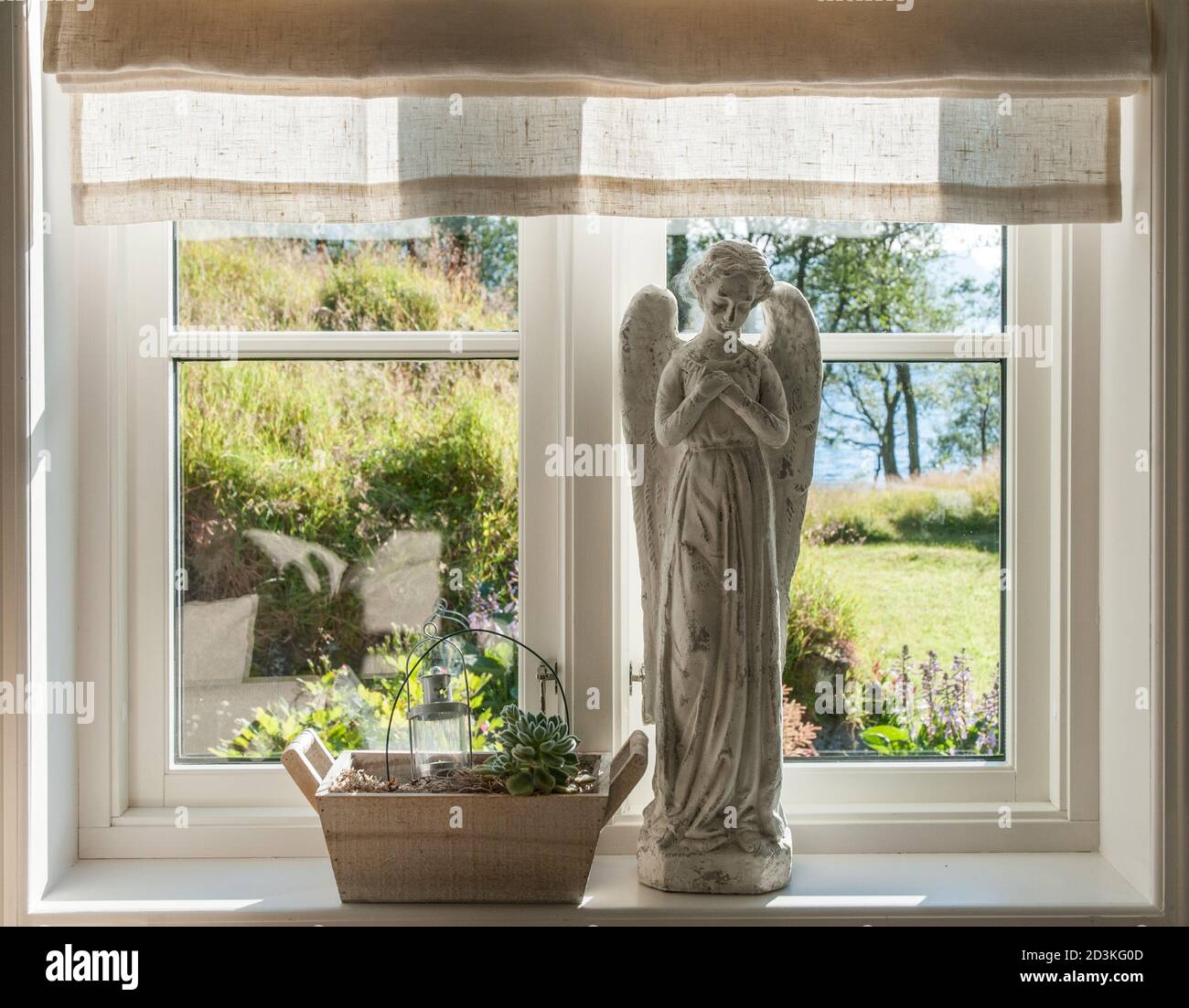 Traditional farmhouse window with an angel sculpture and plant pot on ...