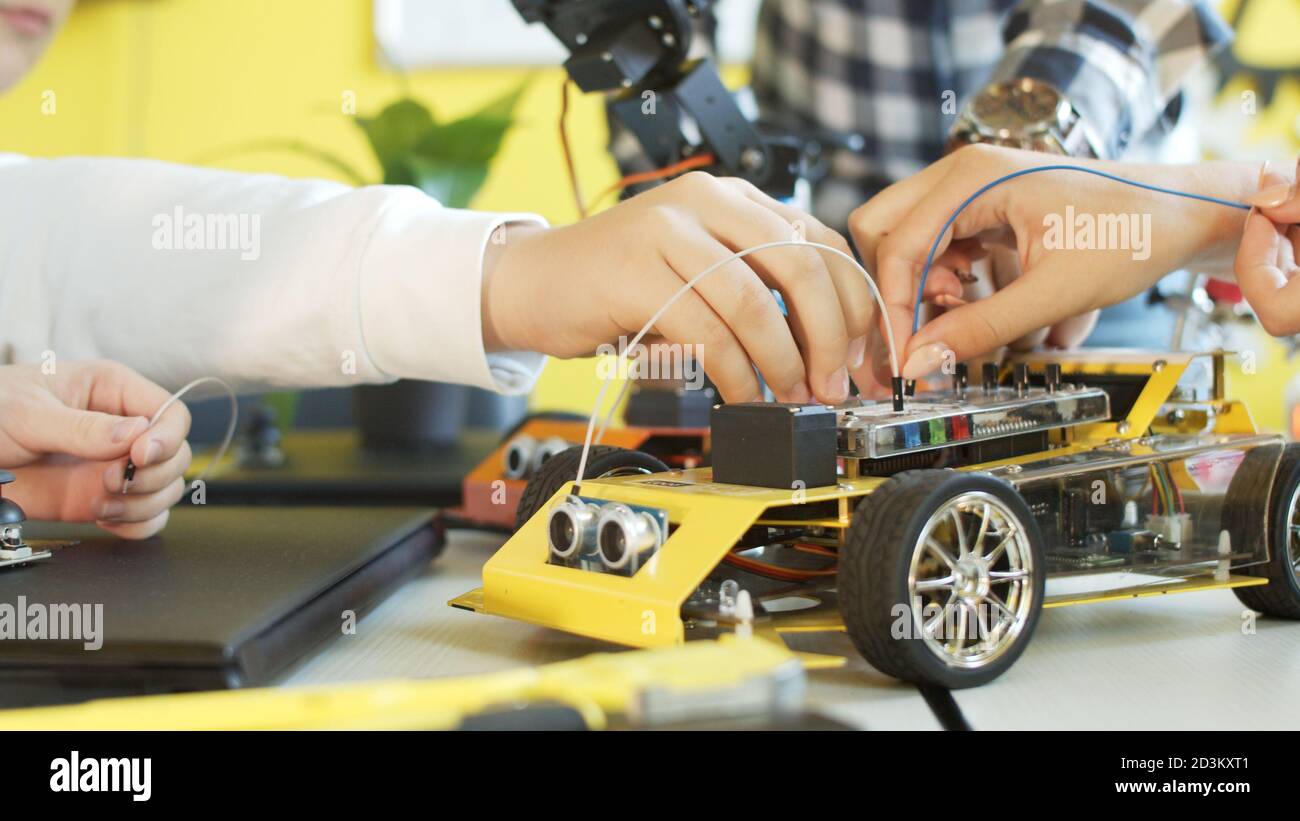 Crop teenager playing with modern robot in class Stock Photo - Alamy