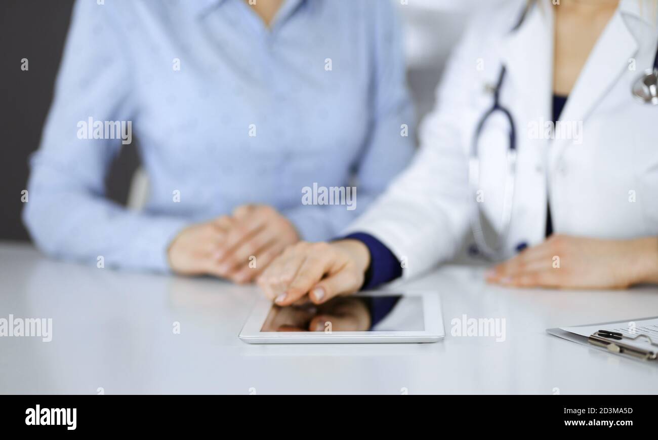 Unknown woman-doctor is showing to her patient a description of ...