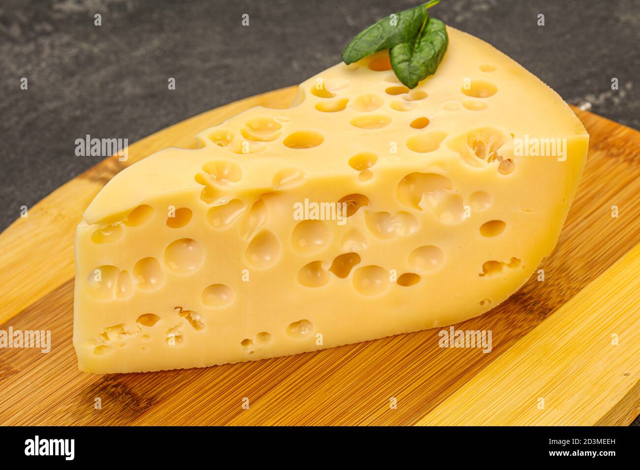 Maasdam cheese - dairy yellow triangle with holes Stock Photo - Alamy
