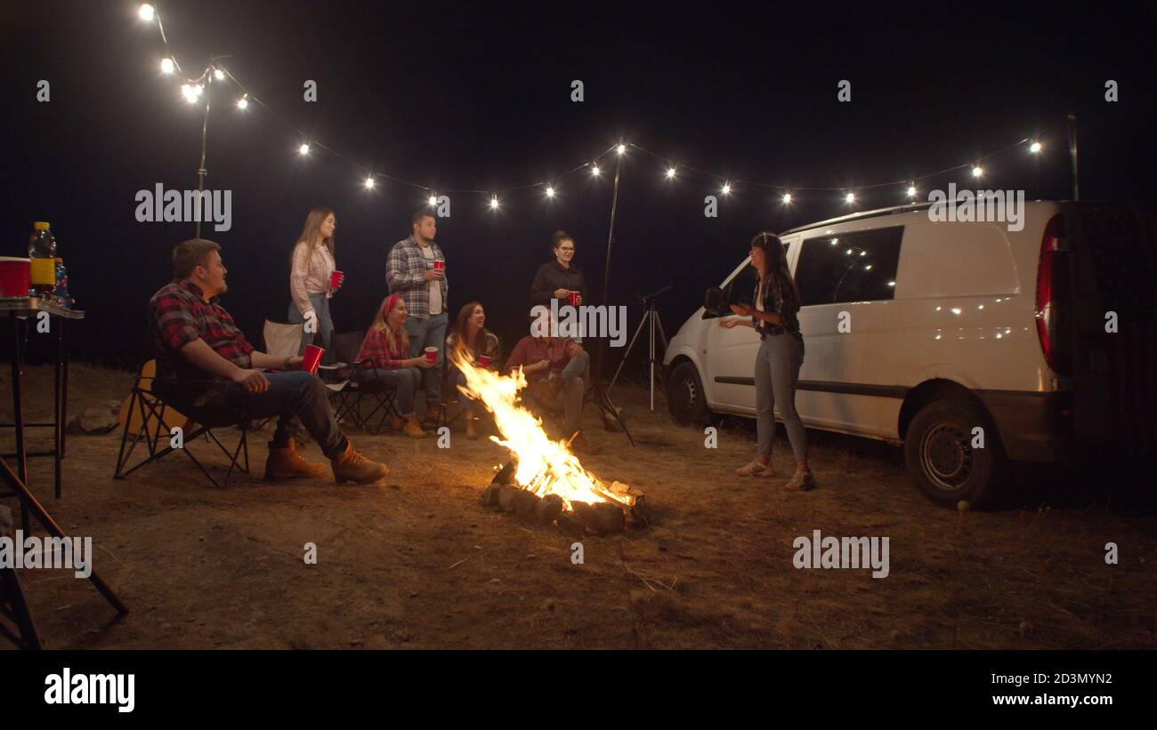 Friends playing charades near campfire at night Stock Photo - Alamy
