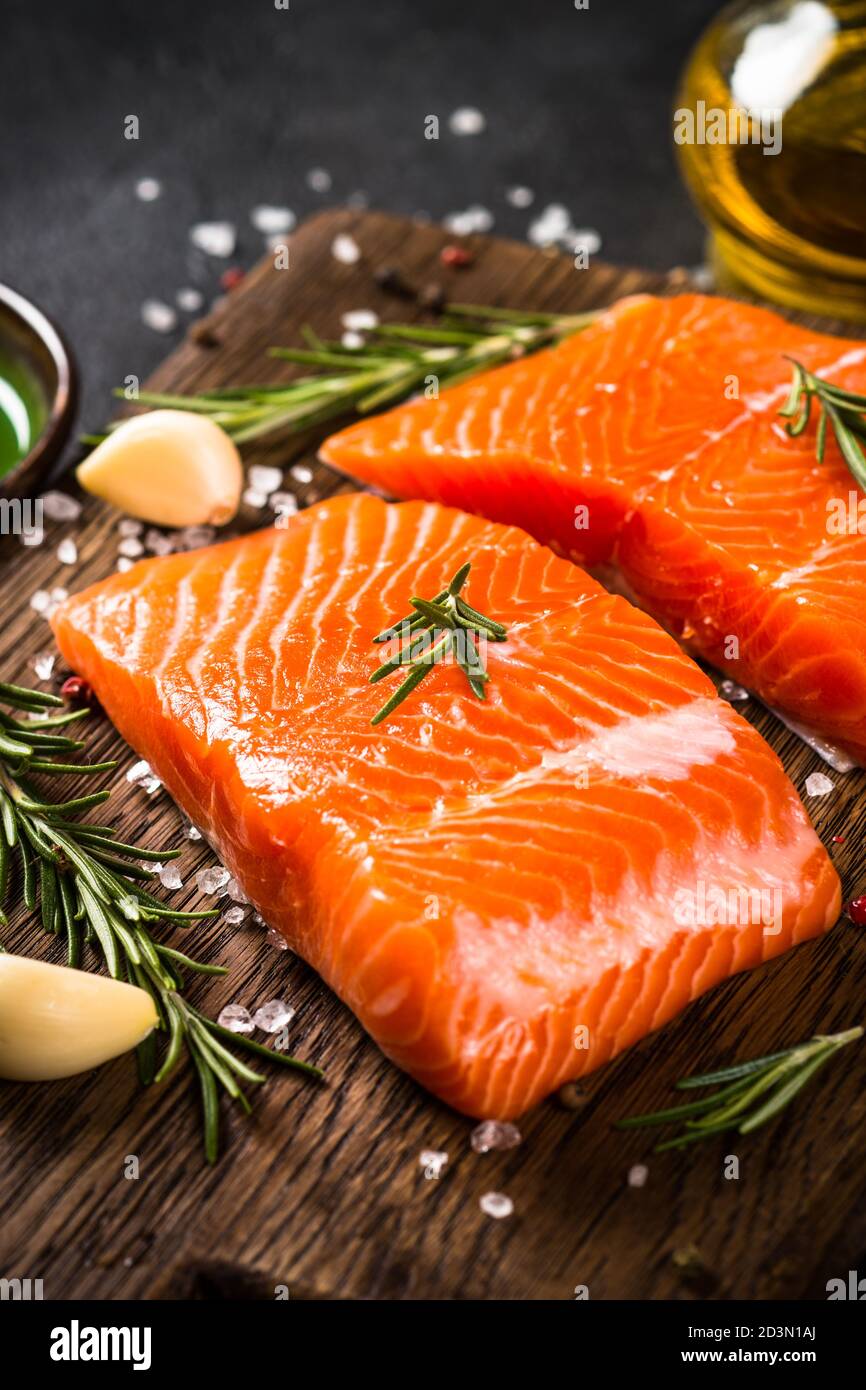 Salmon fish with ingredients at black table Stock Photo - Alamy