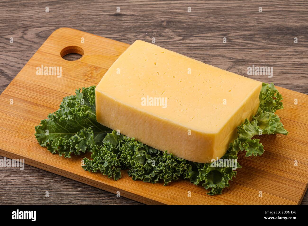 Tasty yelloow Tilsiter cheese brick over board Stock Photo - Alamy