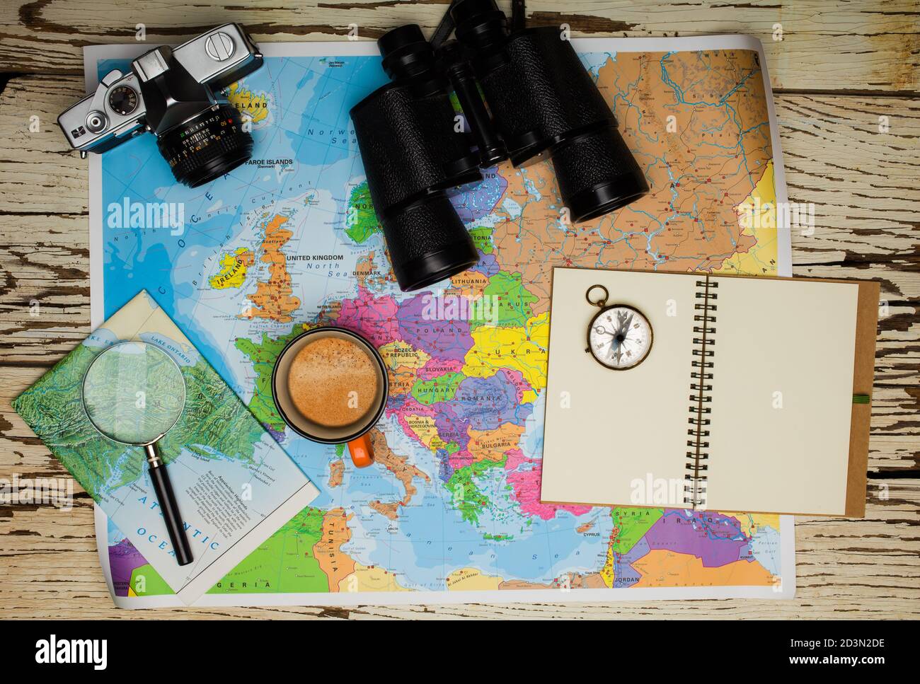 Flat lay of the travel planning concept. Top view of a diary, binoculars, compass, retro photo ...