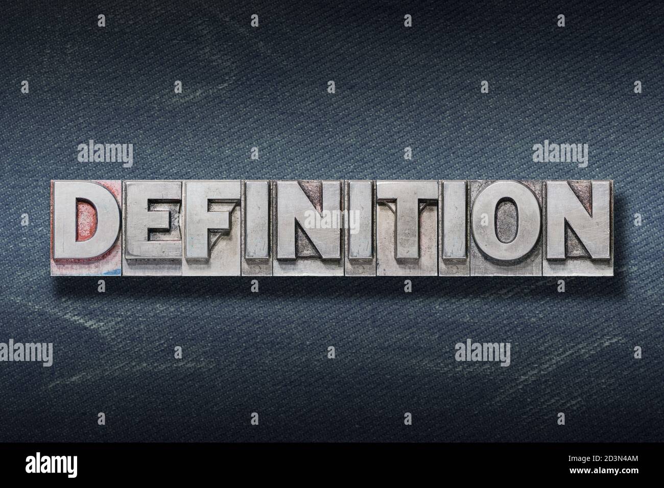 definition word made from metallic letterpress on dark jeans background ...