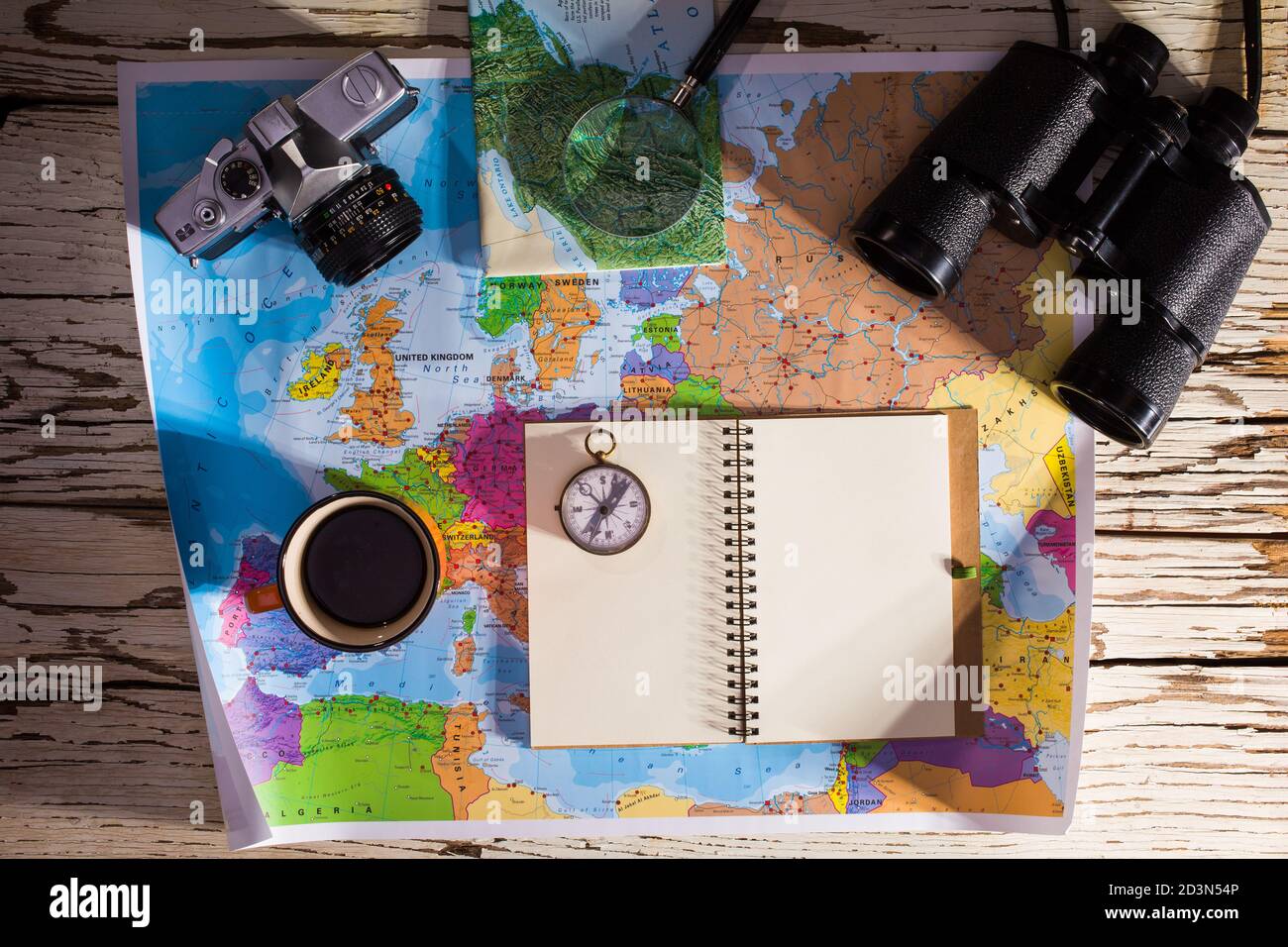 Flat lay of the travel planning concept. Top view of a diary, binoculars, compass, retro photo ...