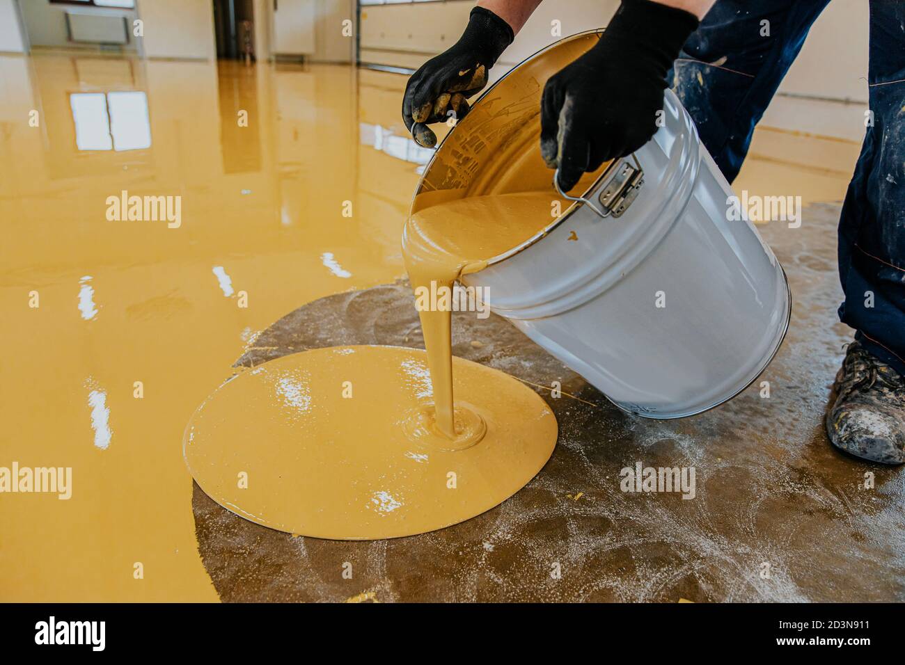 A construction worker apply epoxy resin in an industrial hall Stock ...