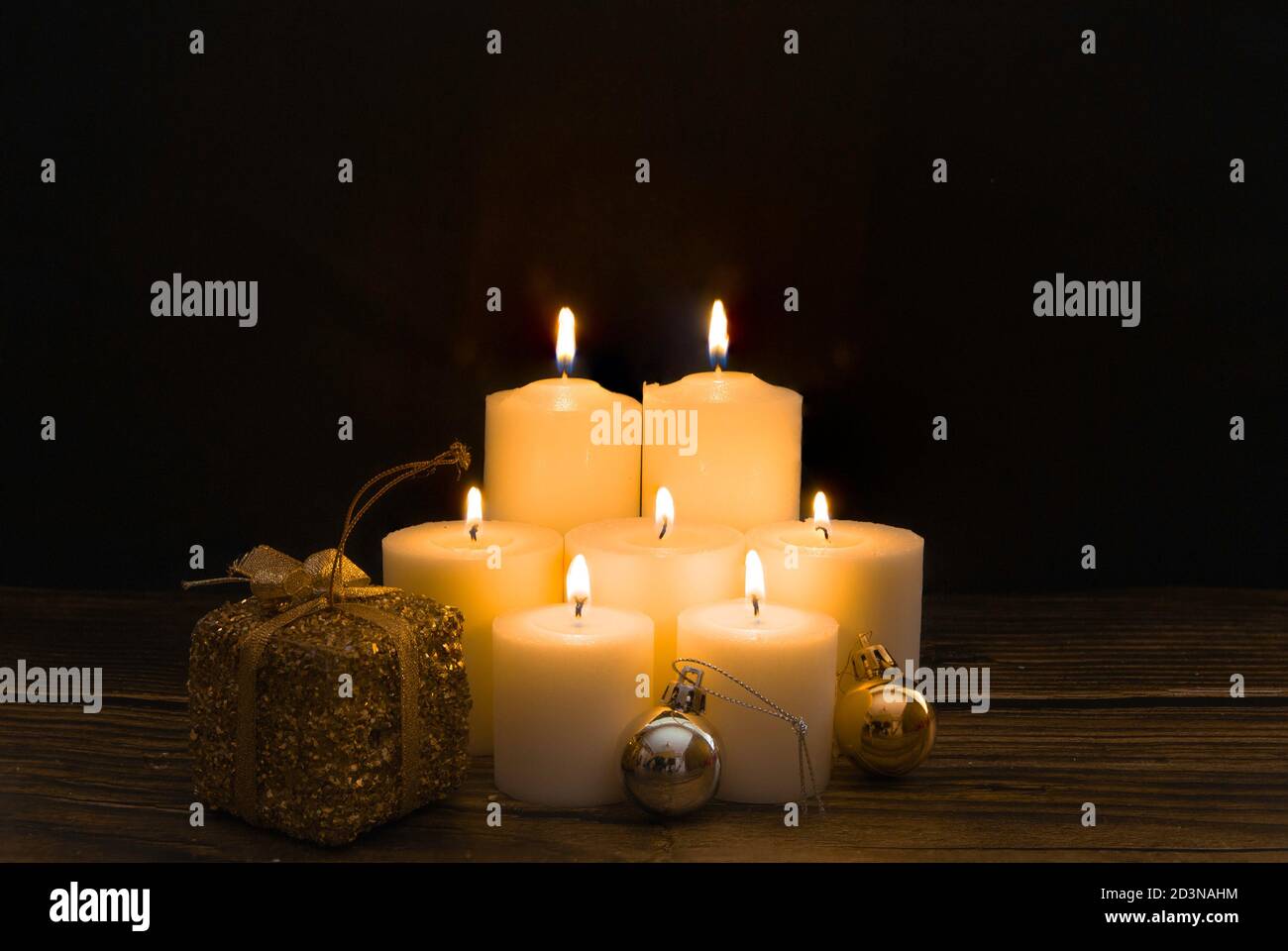 Group of seven burning candles with Christmas details with golden tones ...