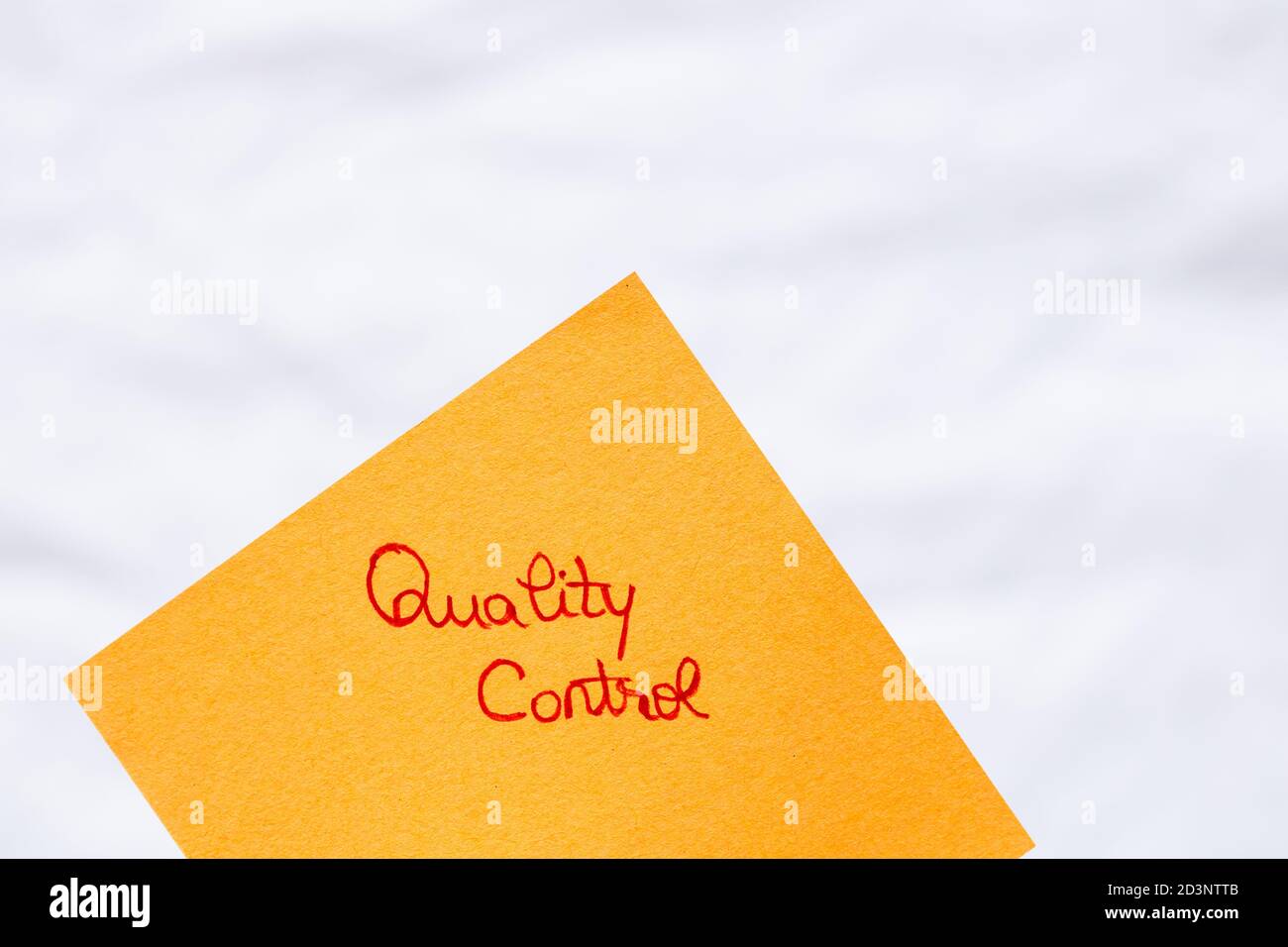 Quality control handwriting text close up isolated on orange paper with ...