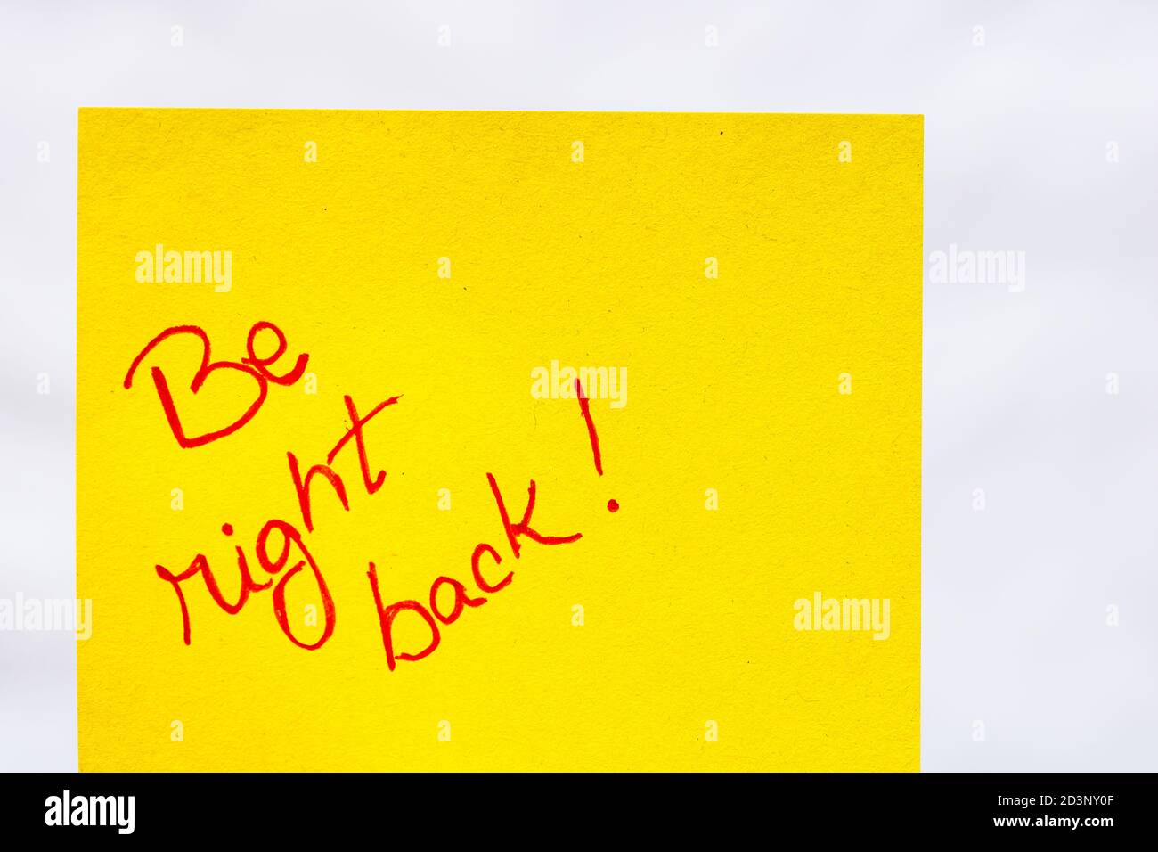 Be right back handwriting text close up isolated on orange paper with ...