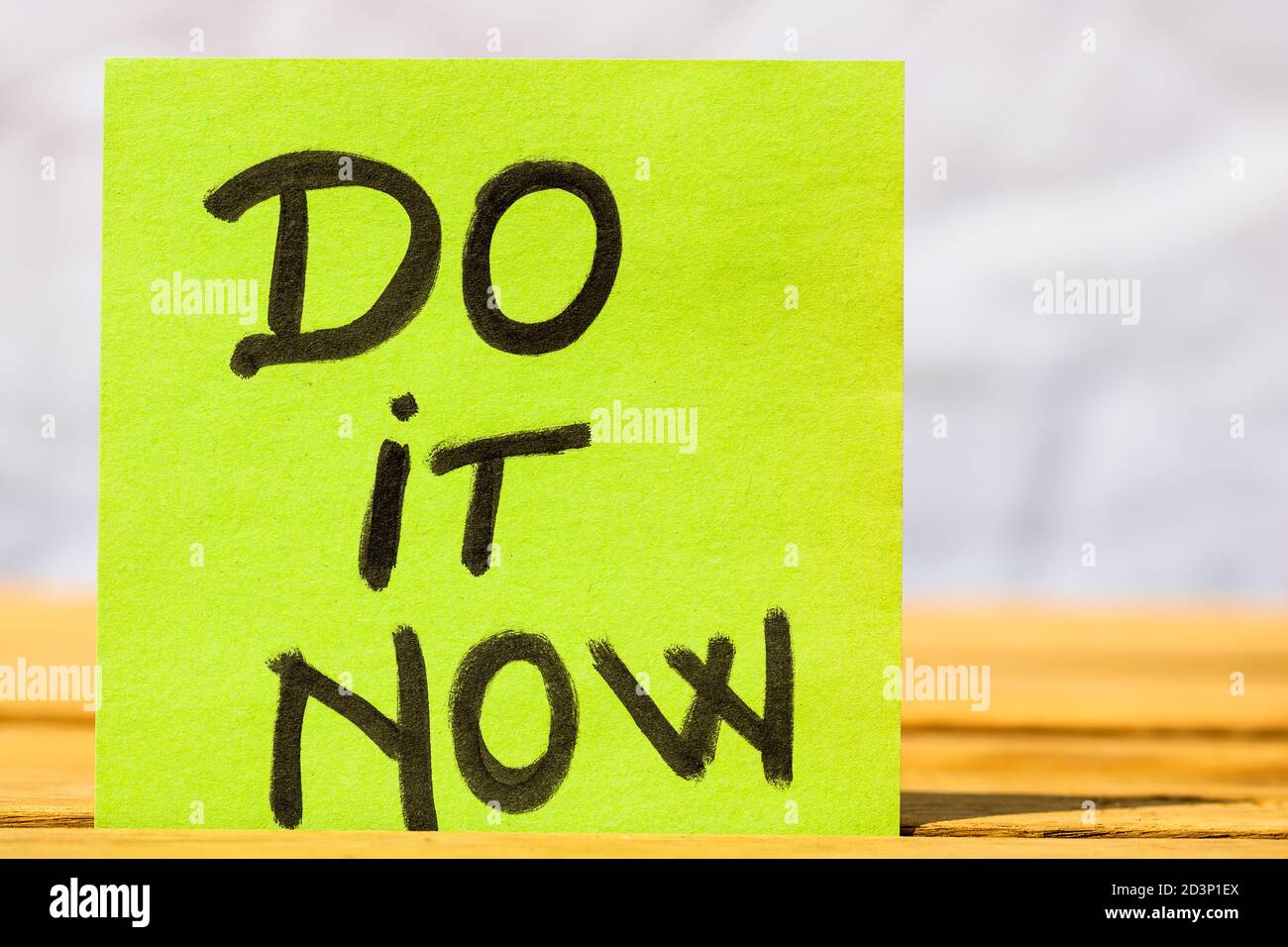 Do it now handwriting text close up isolated on green paper with copy ...